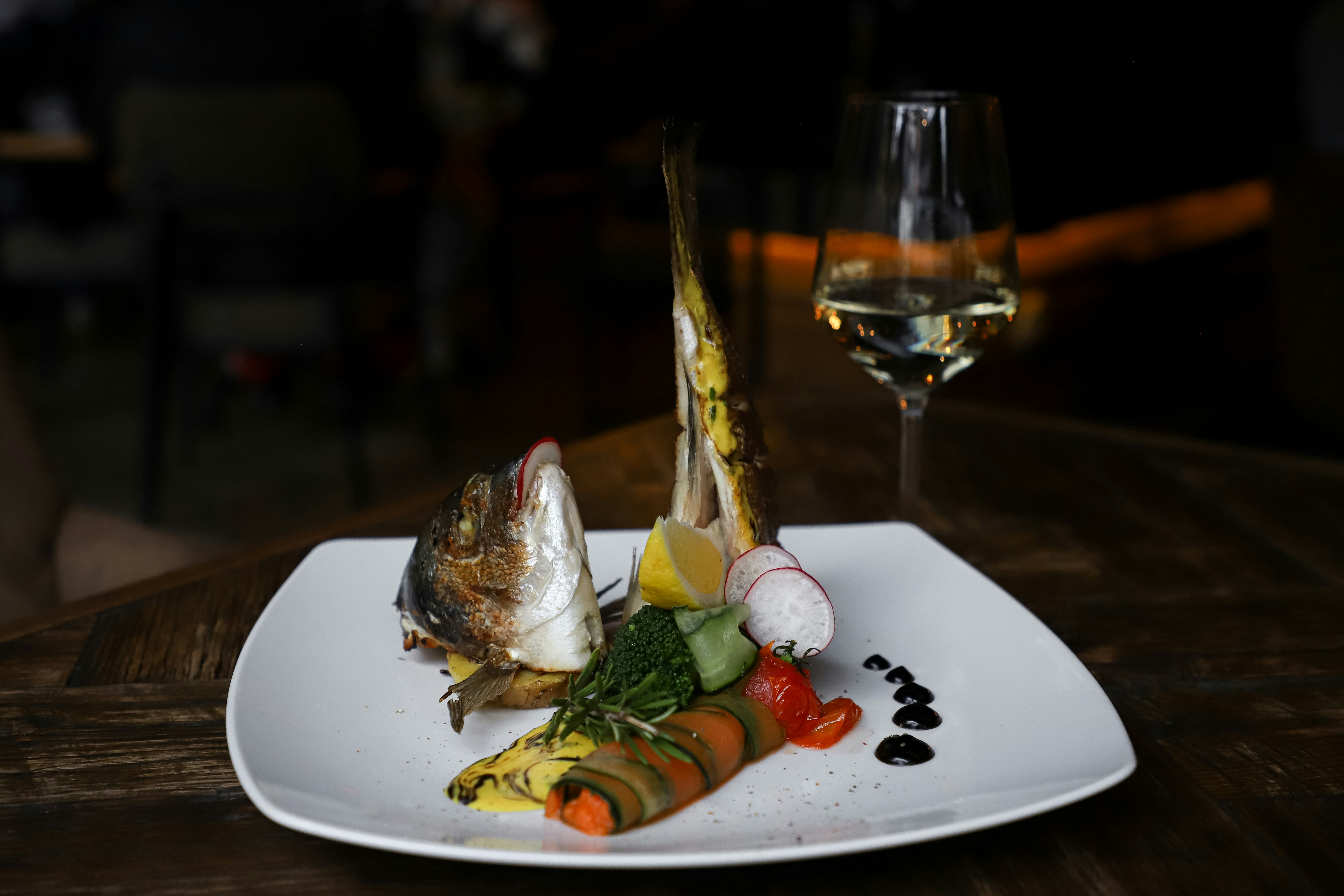 Fish dish served with a glass of wine.