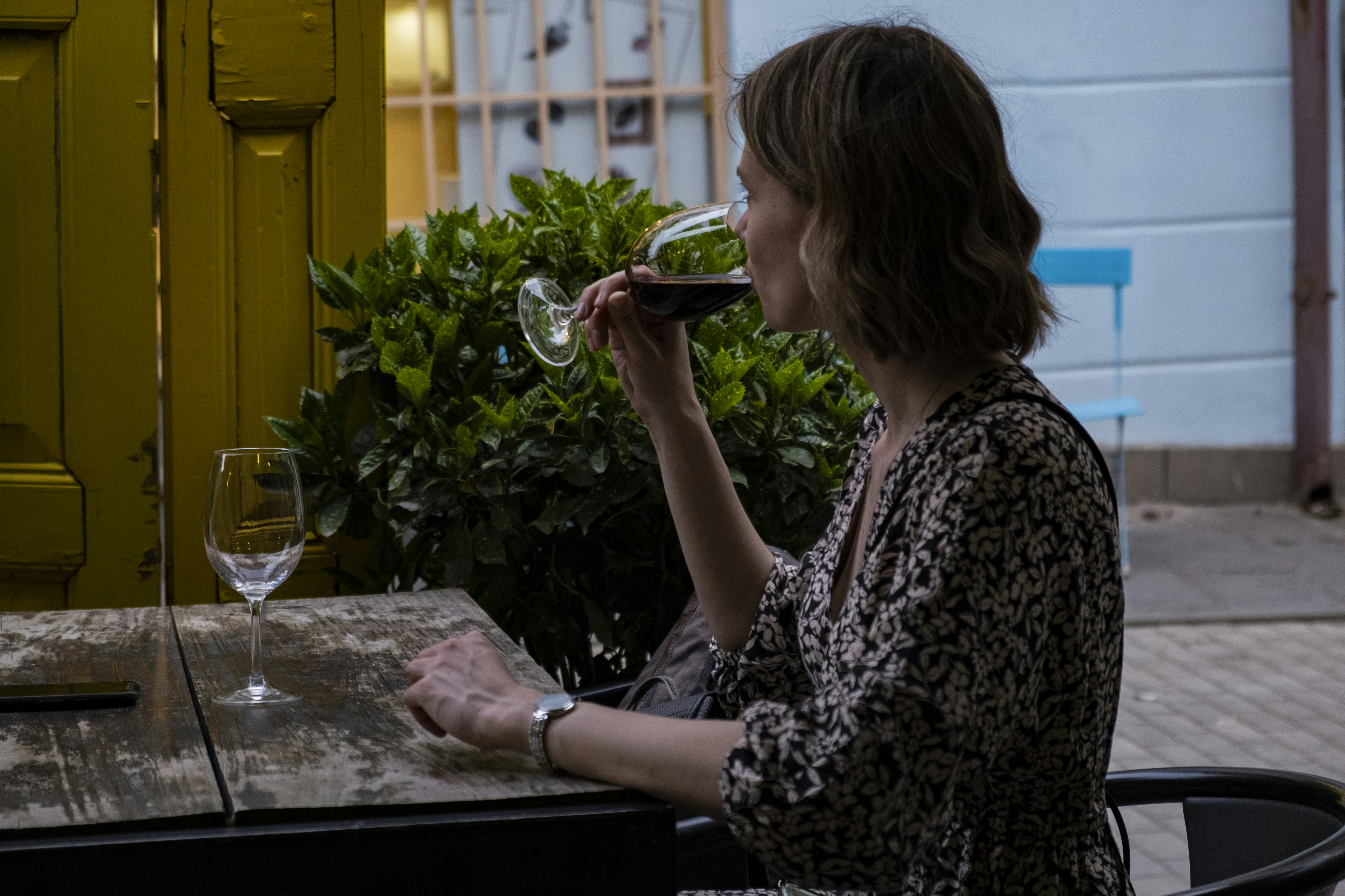 Wine, Shadows, and Yellow Doors: A Quiet Terrace Moment