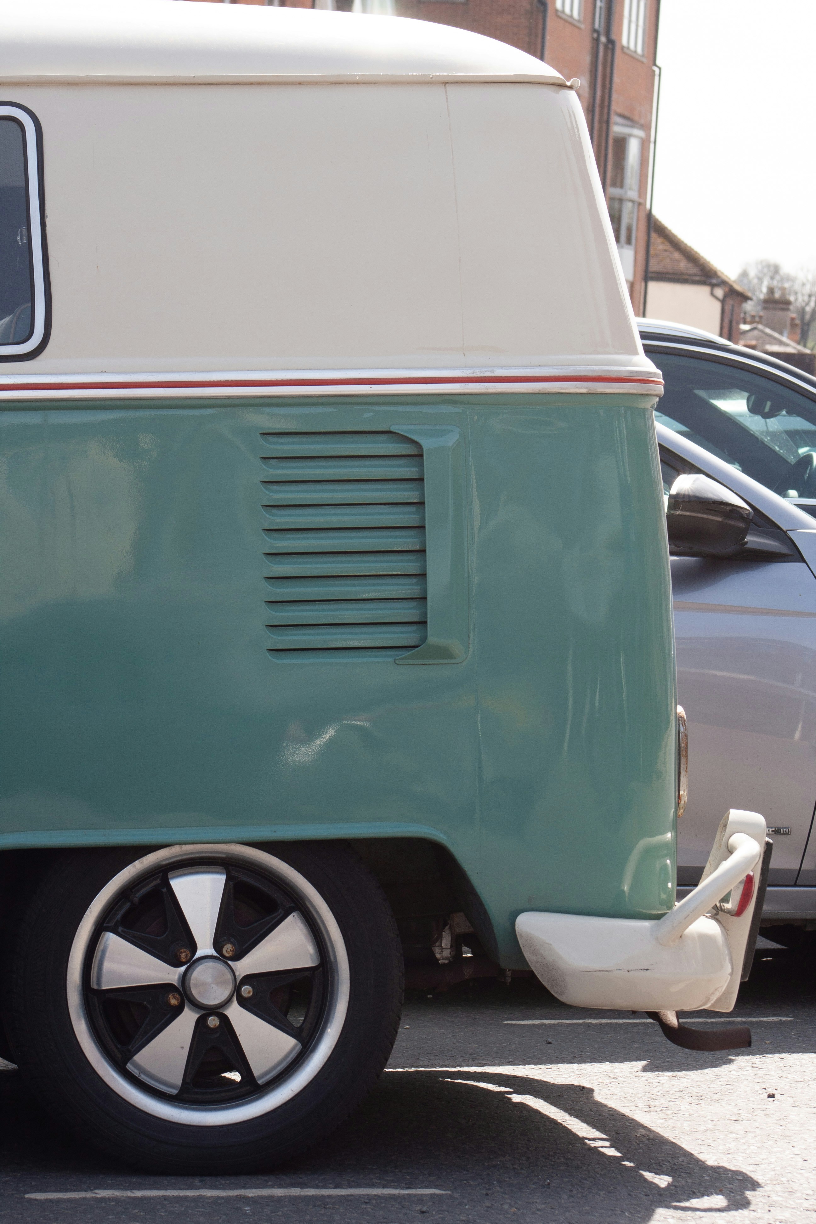 a green van parked next to a car