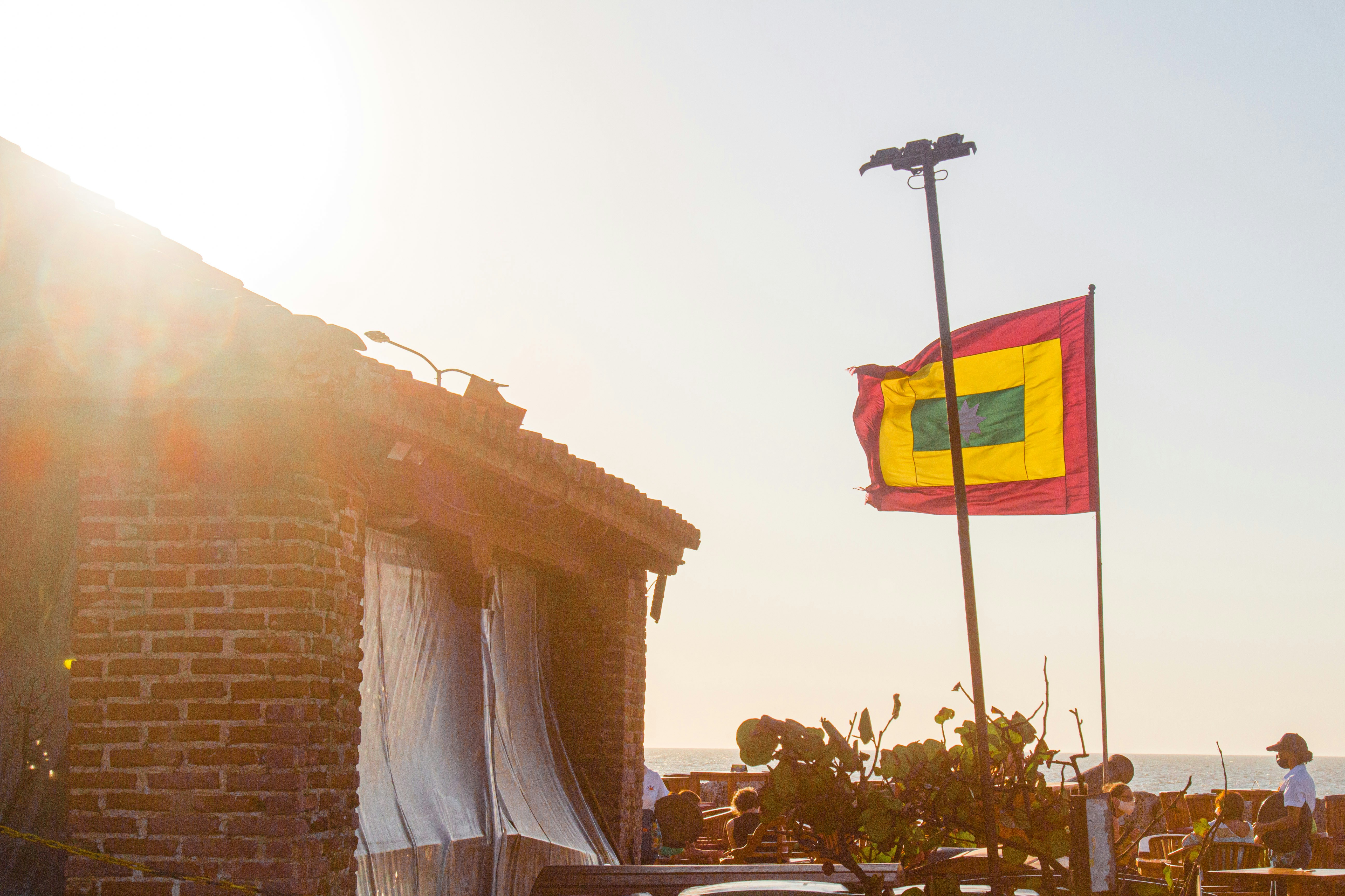 Sunset Light on a Weathered Brick Shack Beside a Flagpole