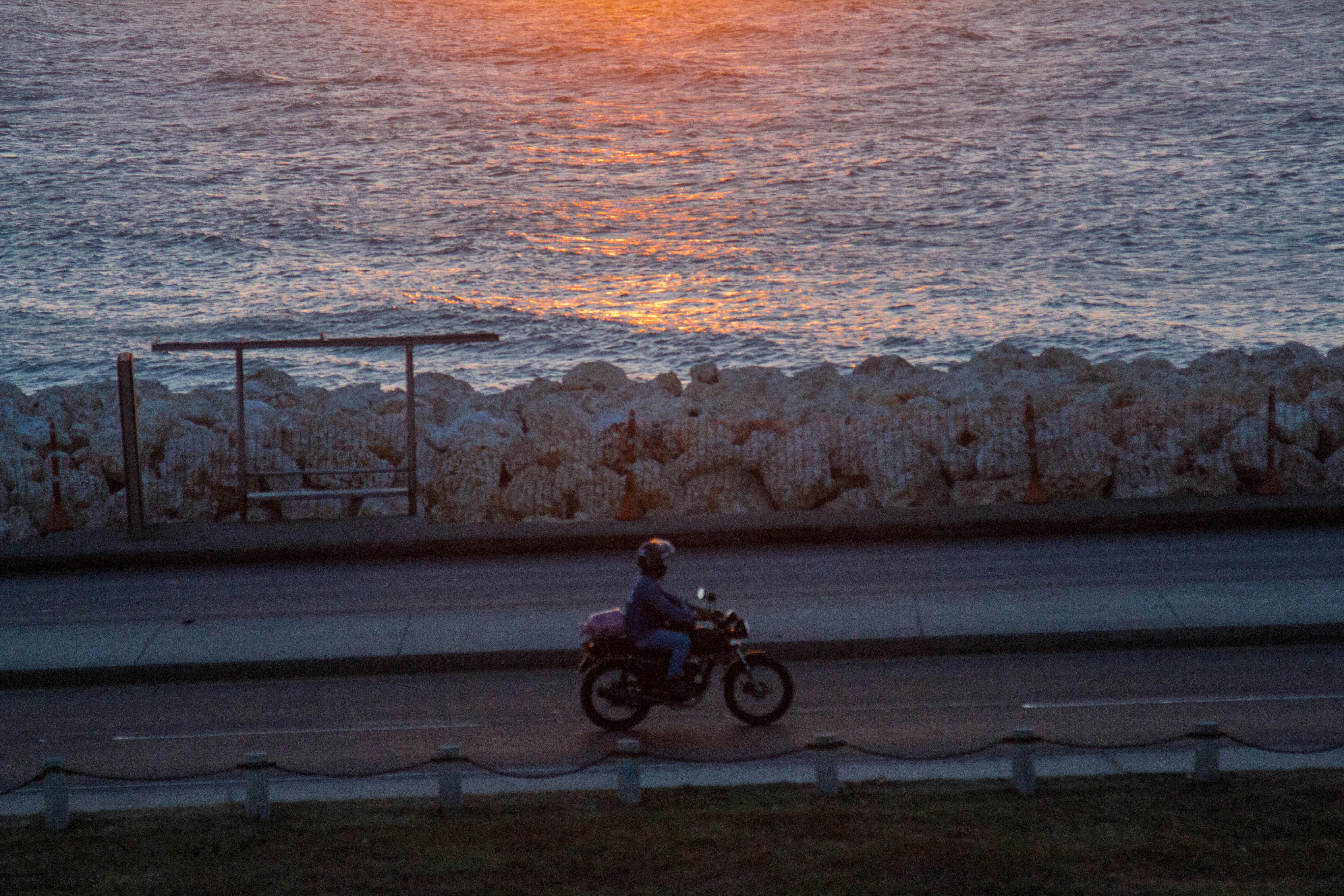 Dusk Rider Along the Seawall by the Quiet Sea