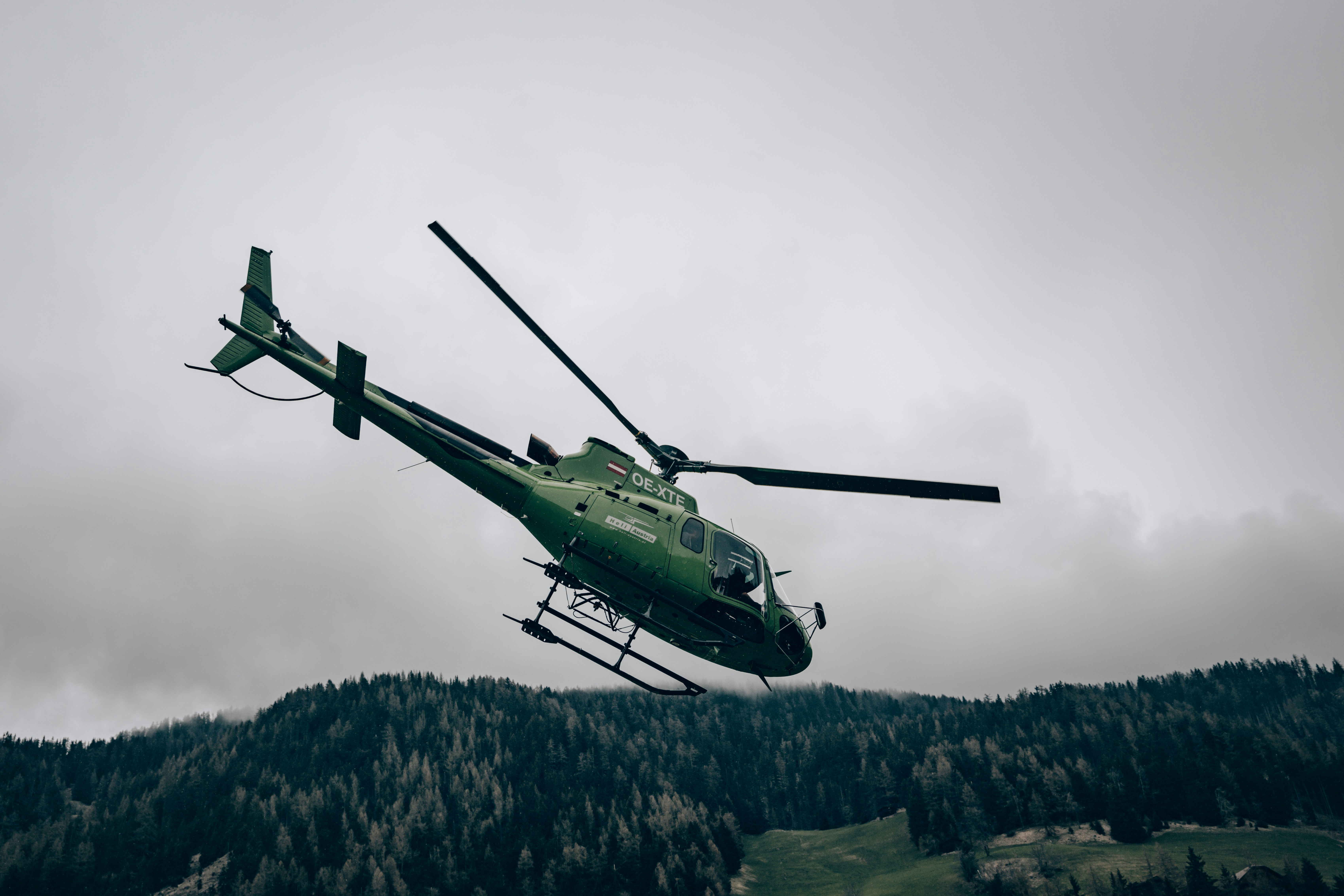 A helicopter flying over trees photo – Free Grey Image on Unsplash