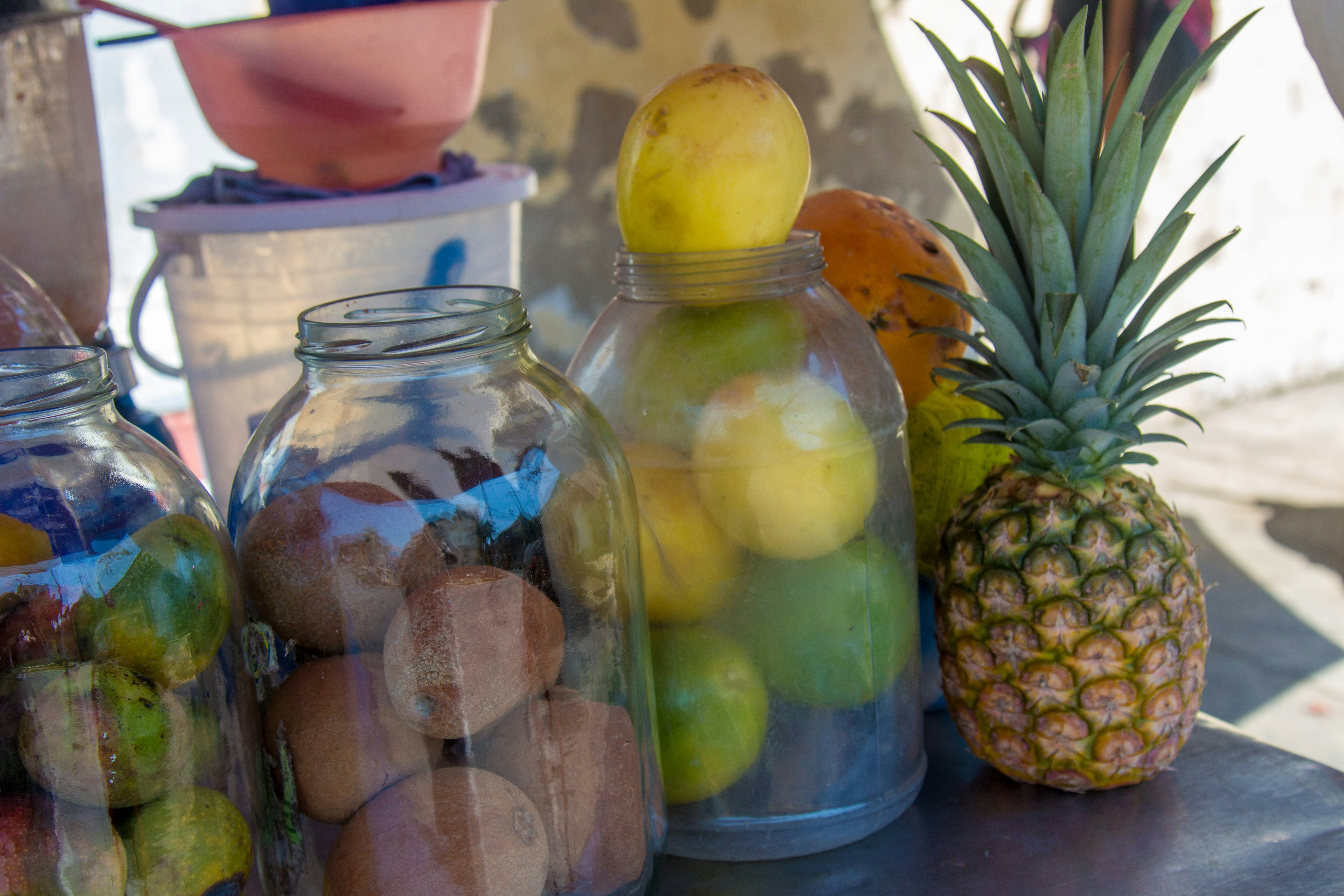a group of glass jars with fruit in them