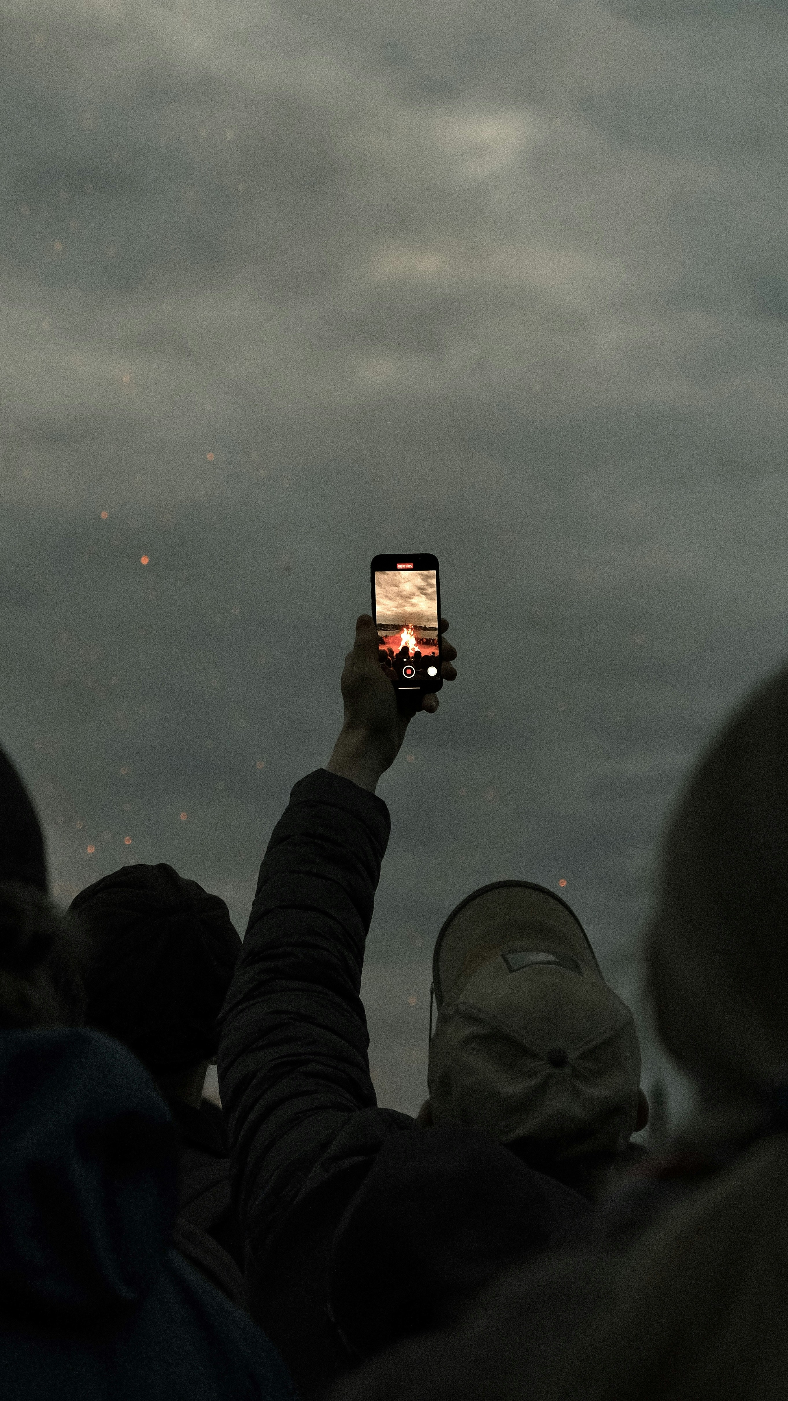 Glow of a Moment: A phone-held Flame Against a Dusky Crowd