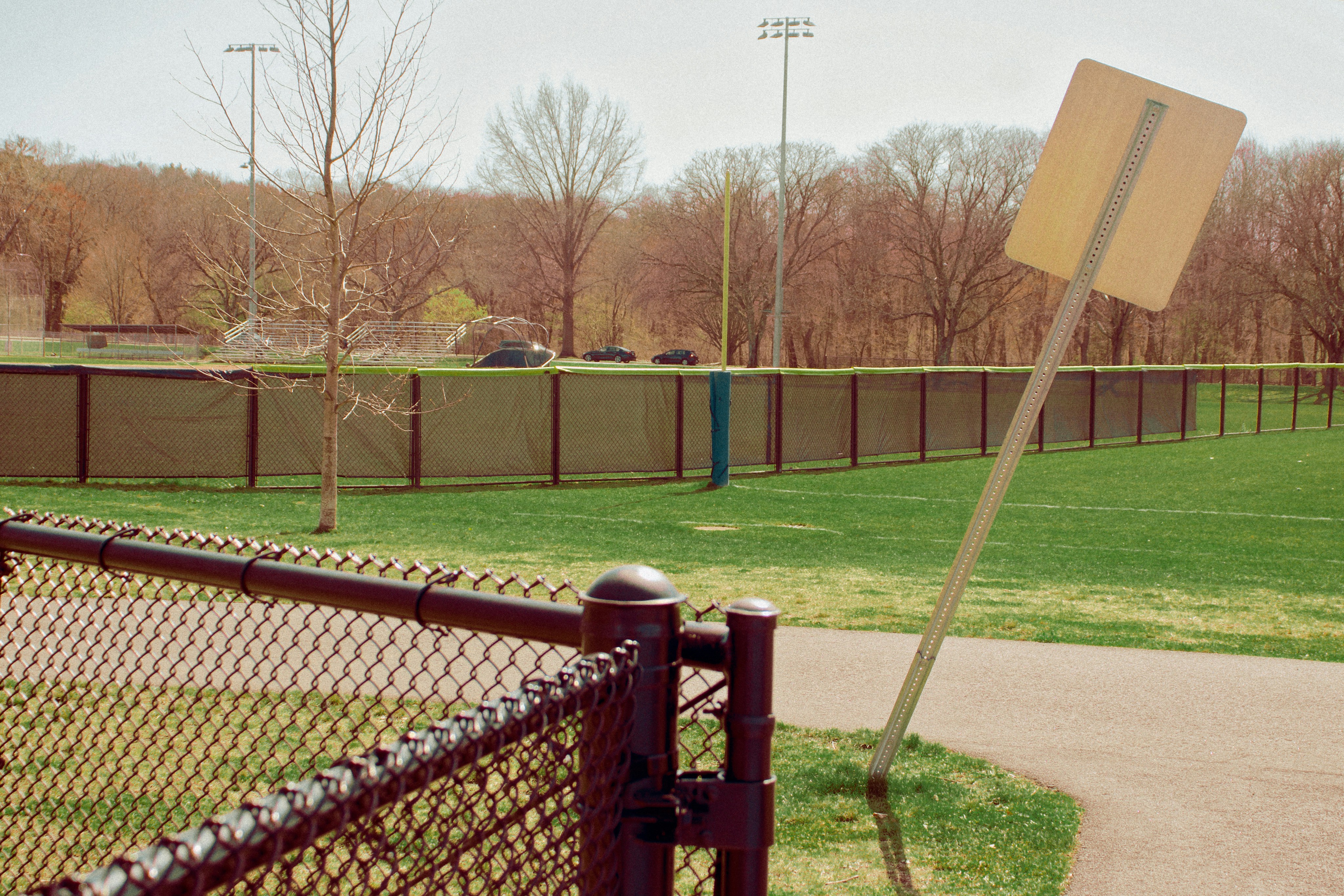 Tilted Signpost, Fenced Field, and Distant Goal Posts