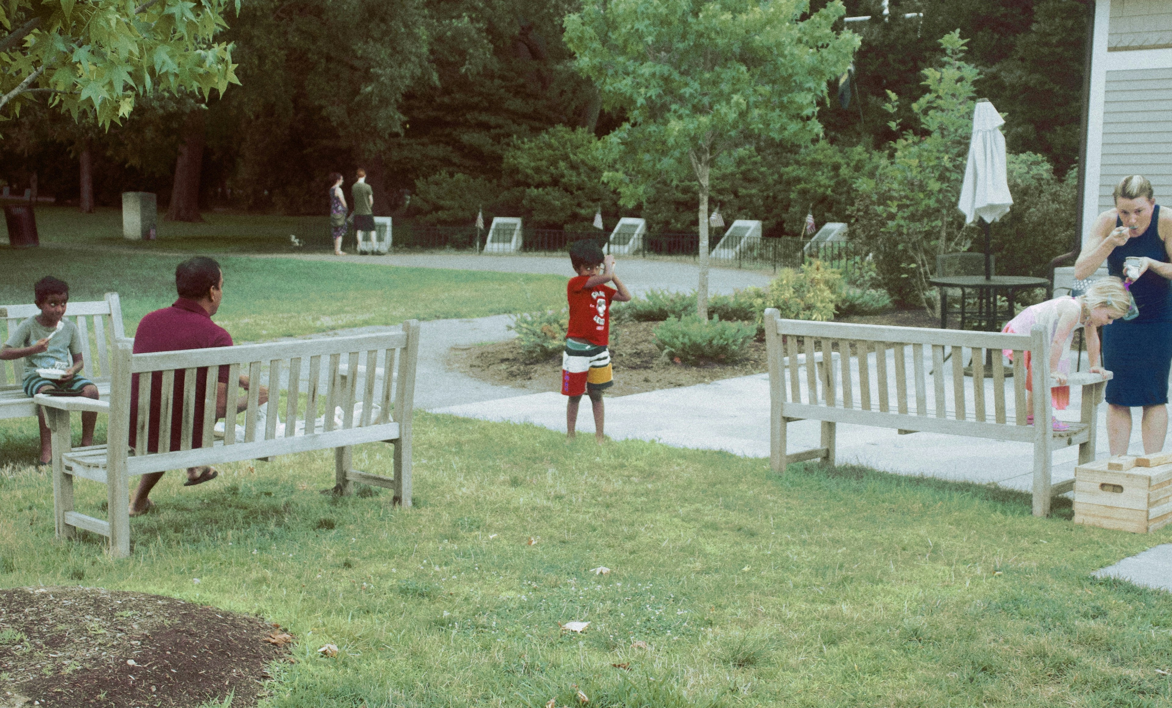 A group of people stand around a bench photo – Free Green Image on Unsplash