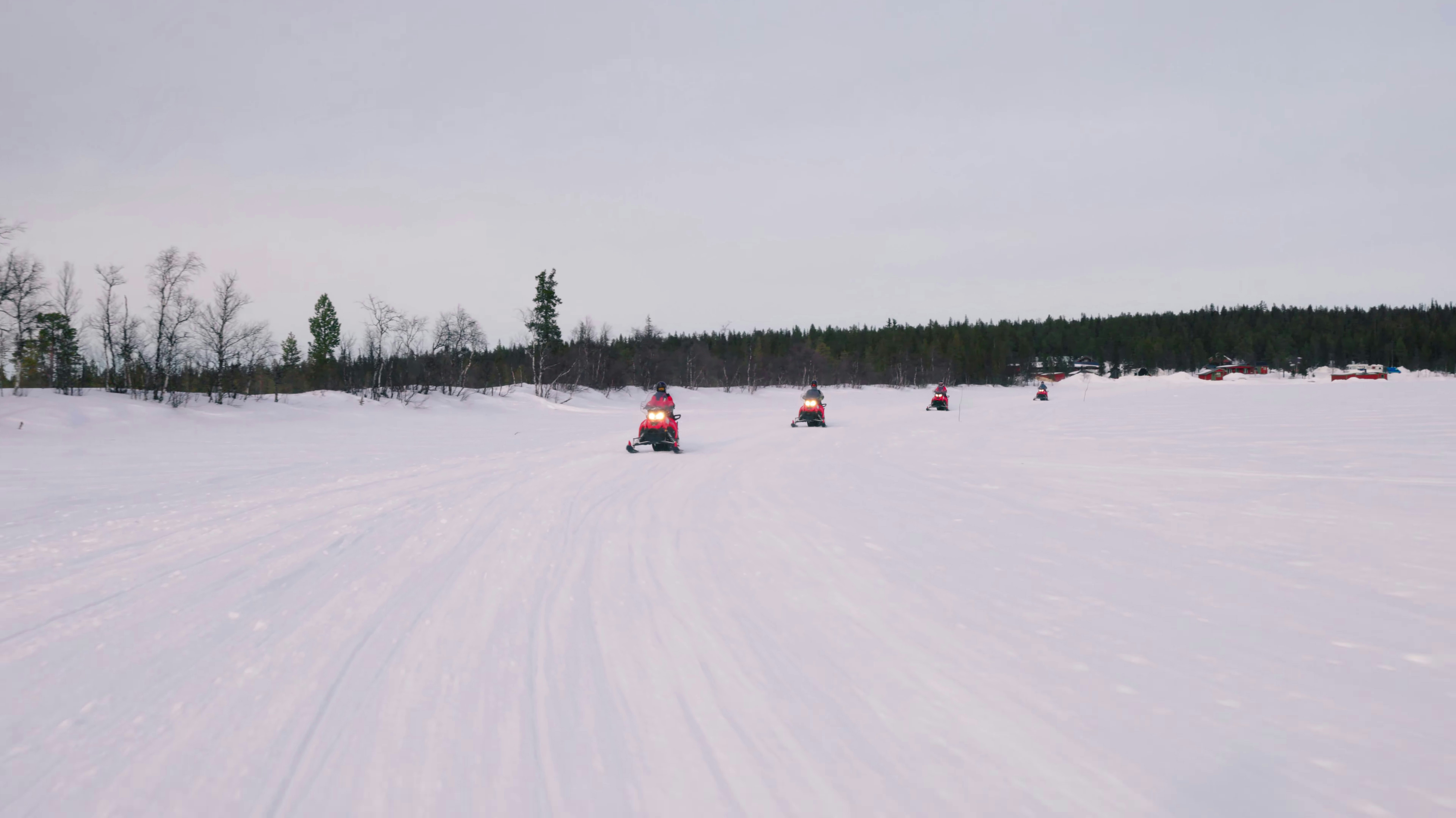 A group of people riding snowmobiles on a snowy field photo – Free ...