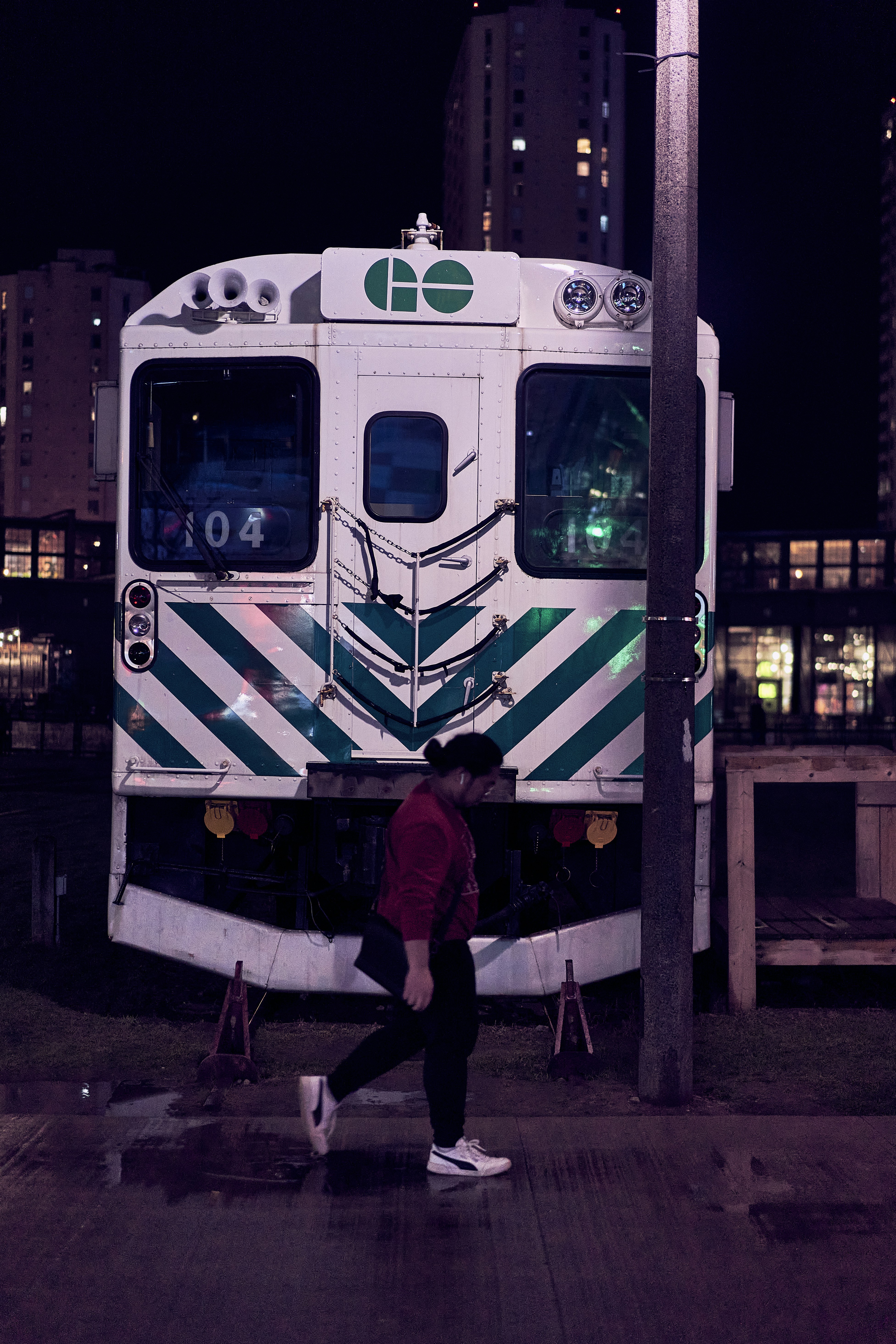 A man walking on a sidewalk next to a train photo – Free Clothing Image ...