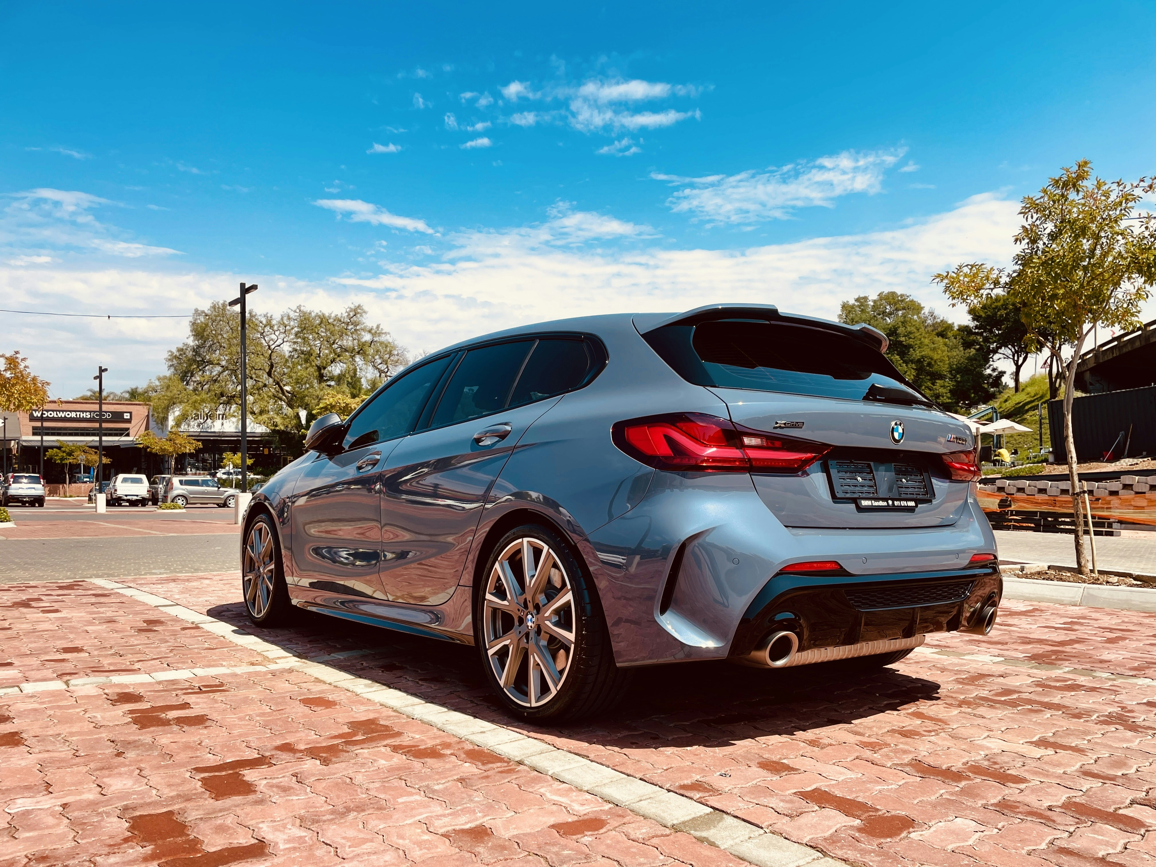 Blue BMW on Brick Courtyard: Modern Curves Under a Clear Sky