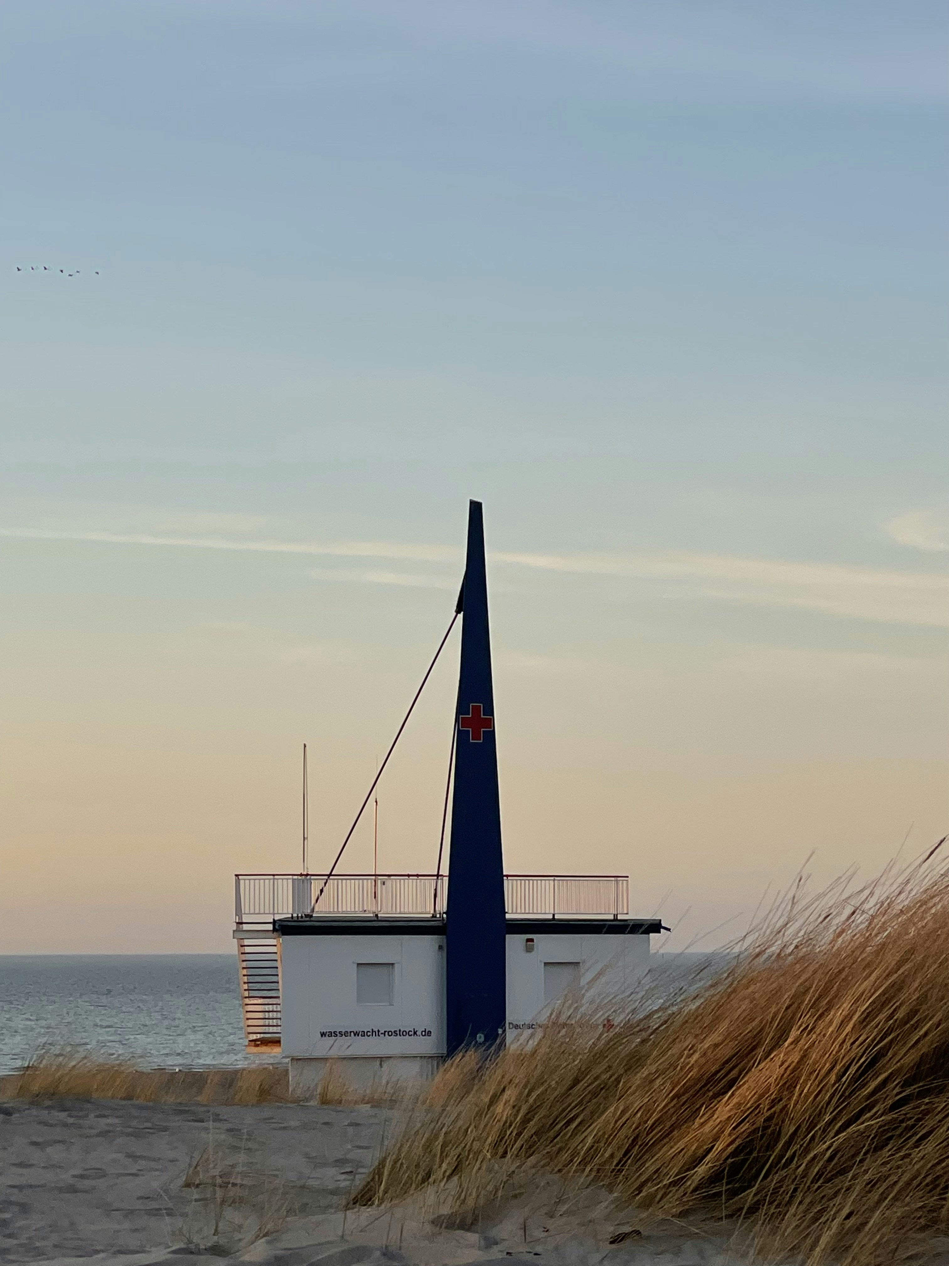 Blue Lifeguard Tower Rising from Dune Grasses at Sunset