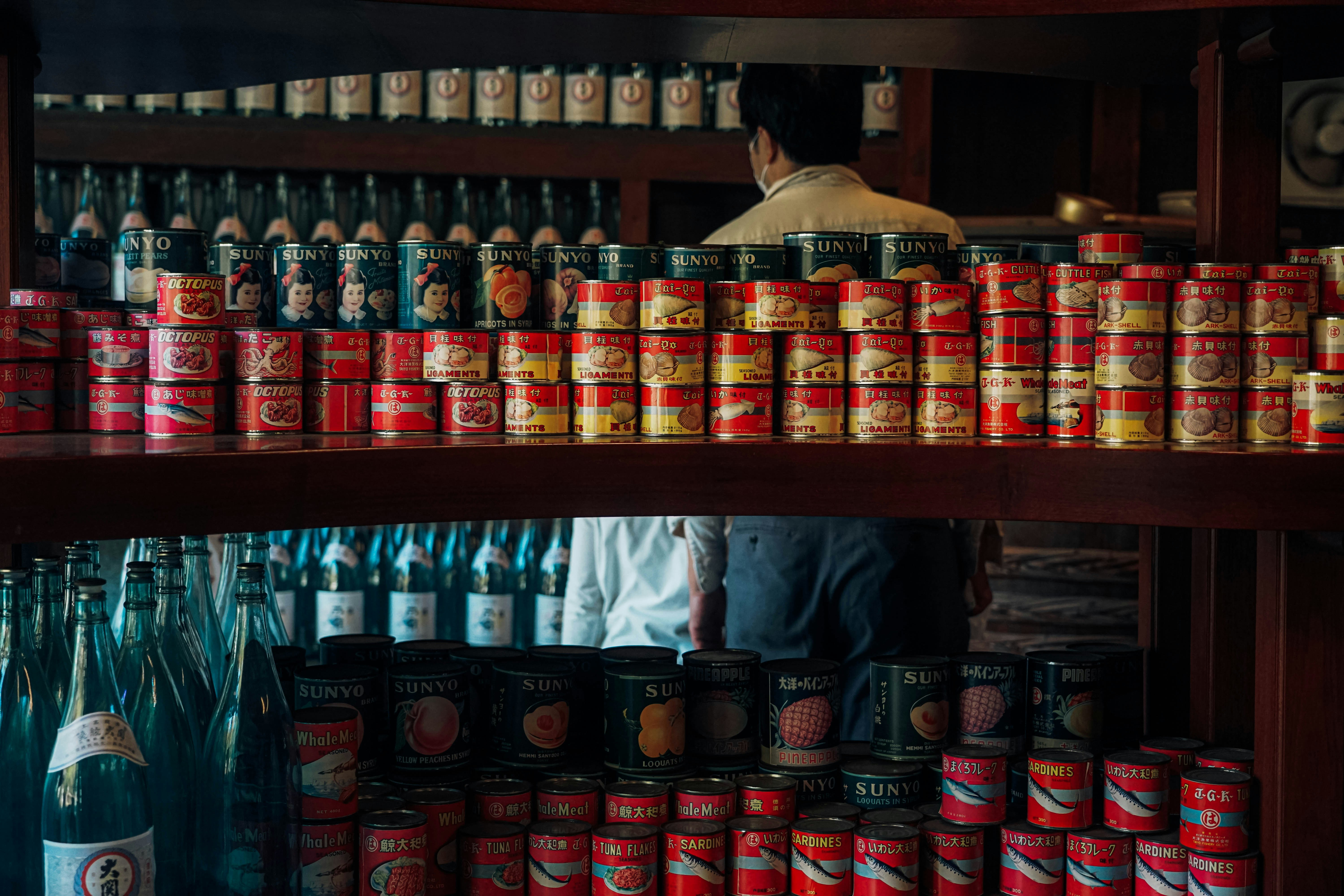 A person behind a counter with many cans of soda photo – Free Vintage ...