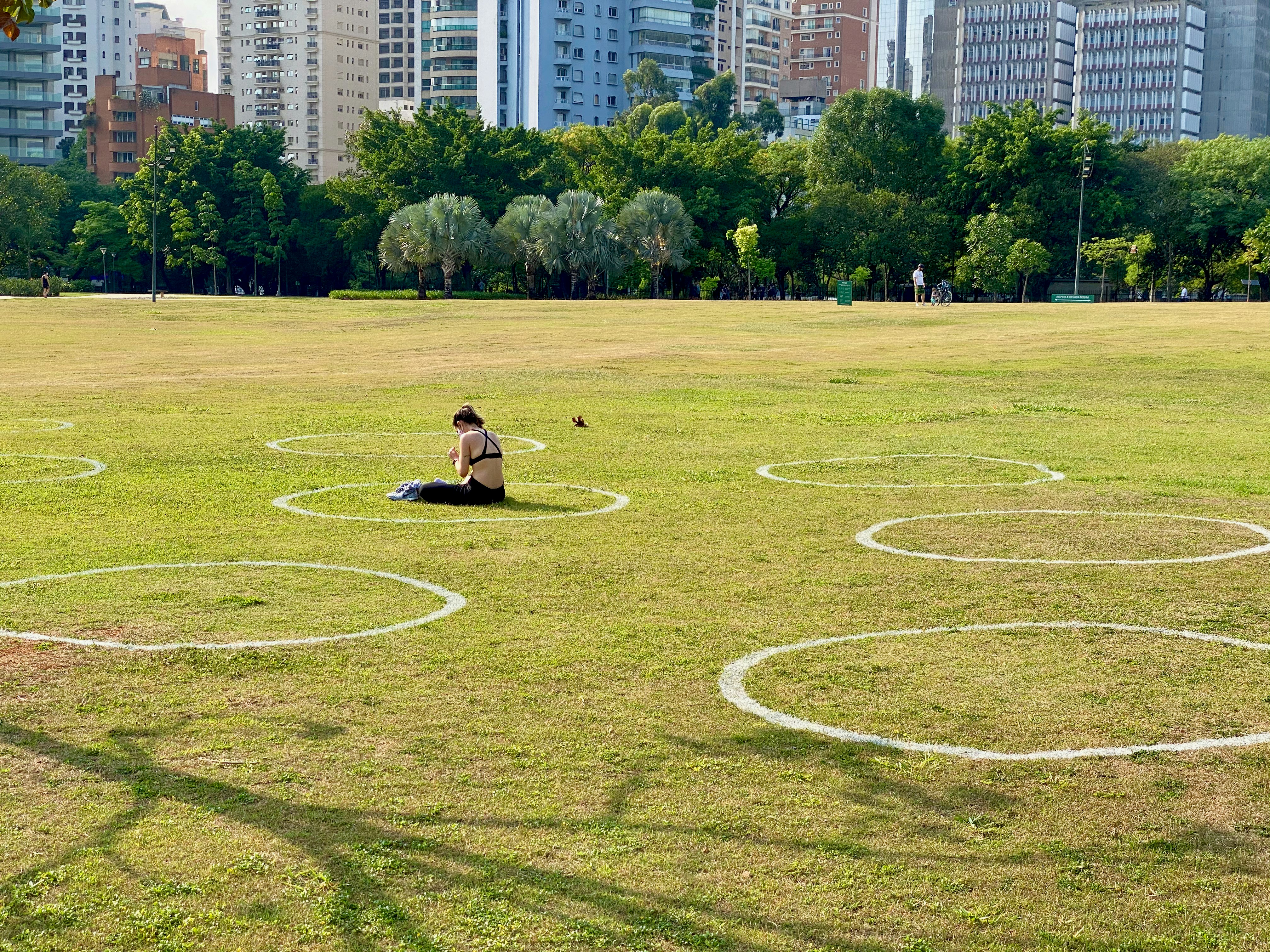 Social distancing at the park | a person sitting on a grassy field