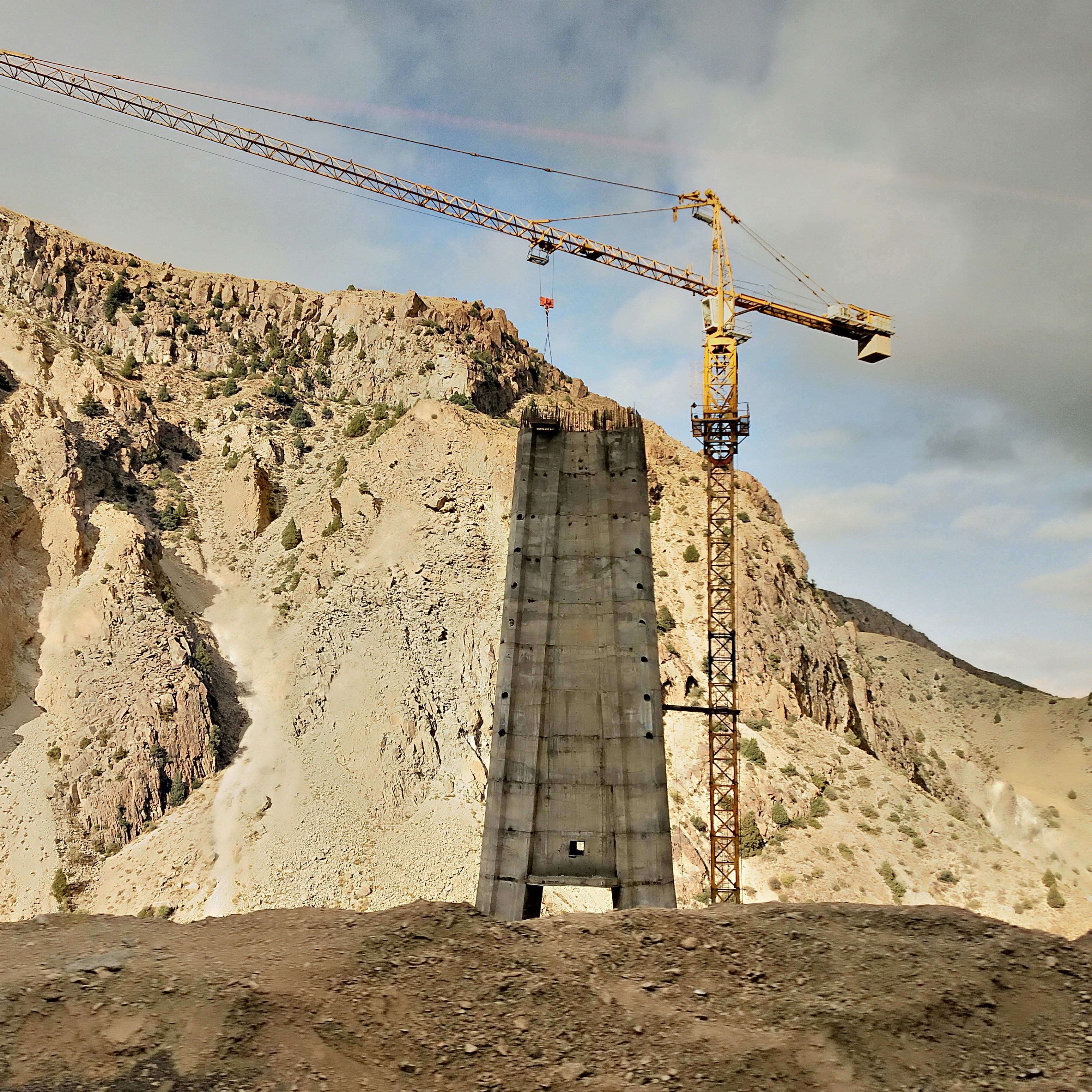 Edge of the Quarry: Tower Crane Standing Guard by a Singular Concrete Pillar
