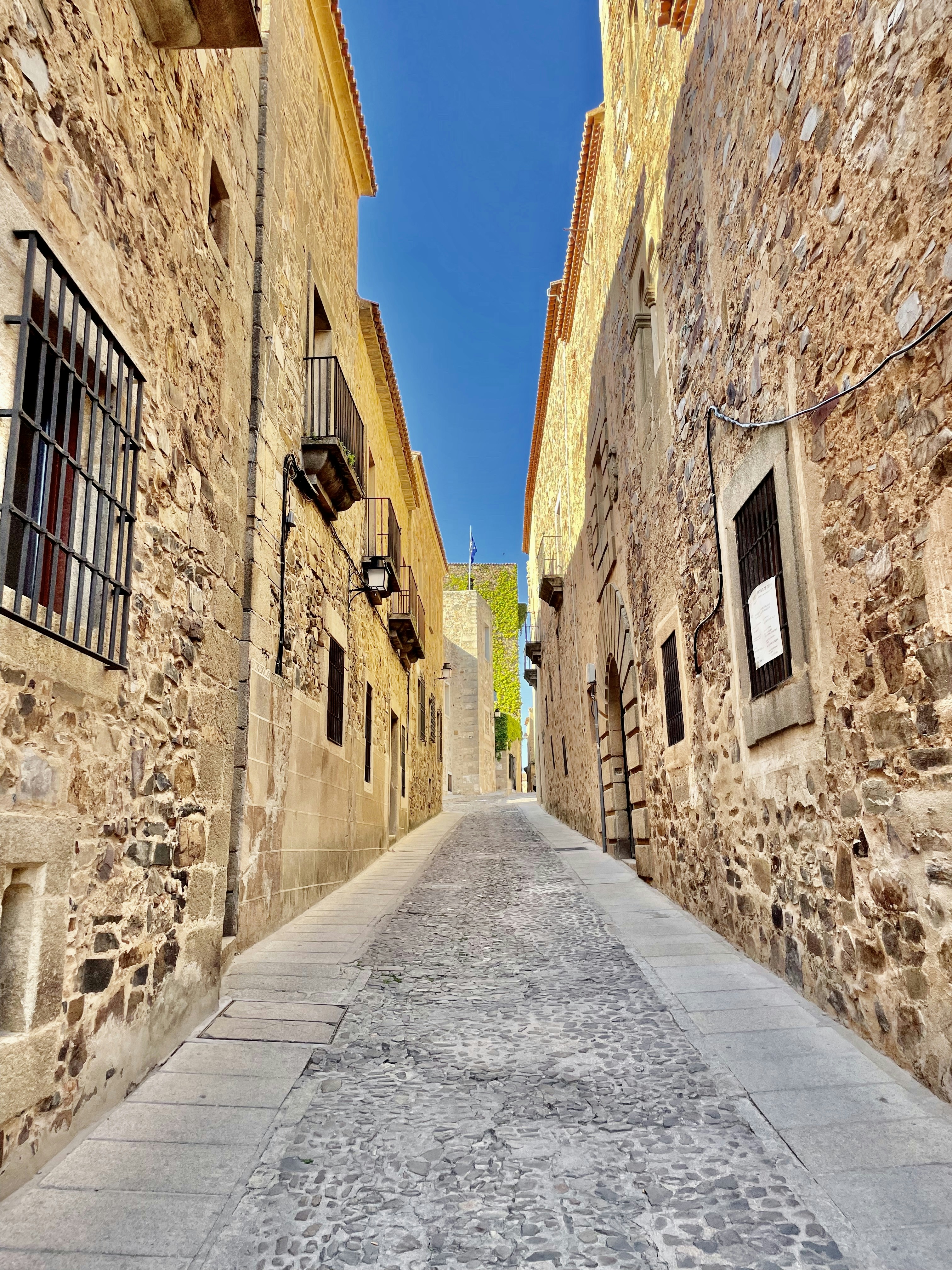 A narrow street between two stone buildings photo – Free Cáceres Image ...