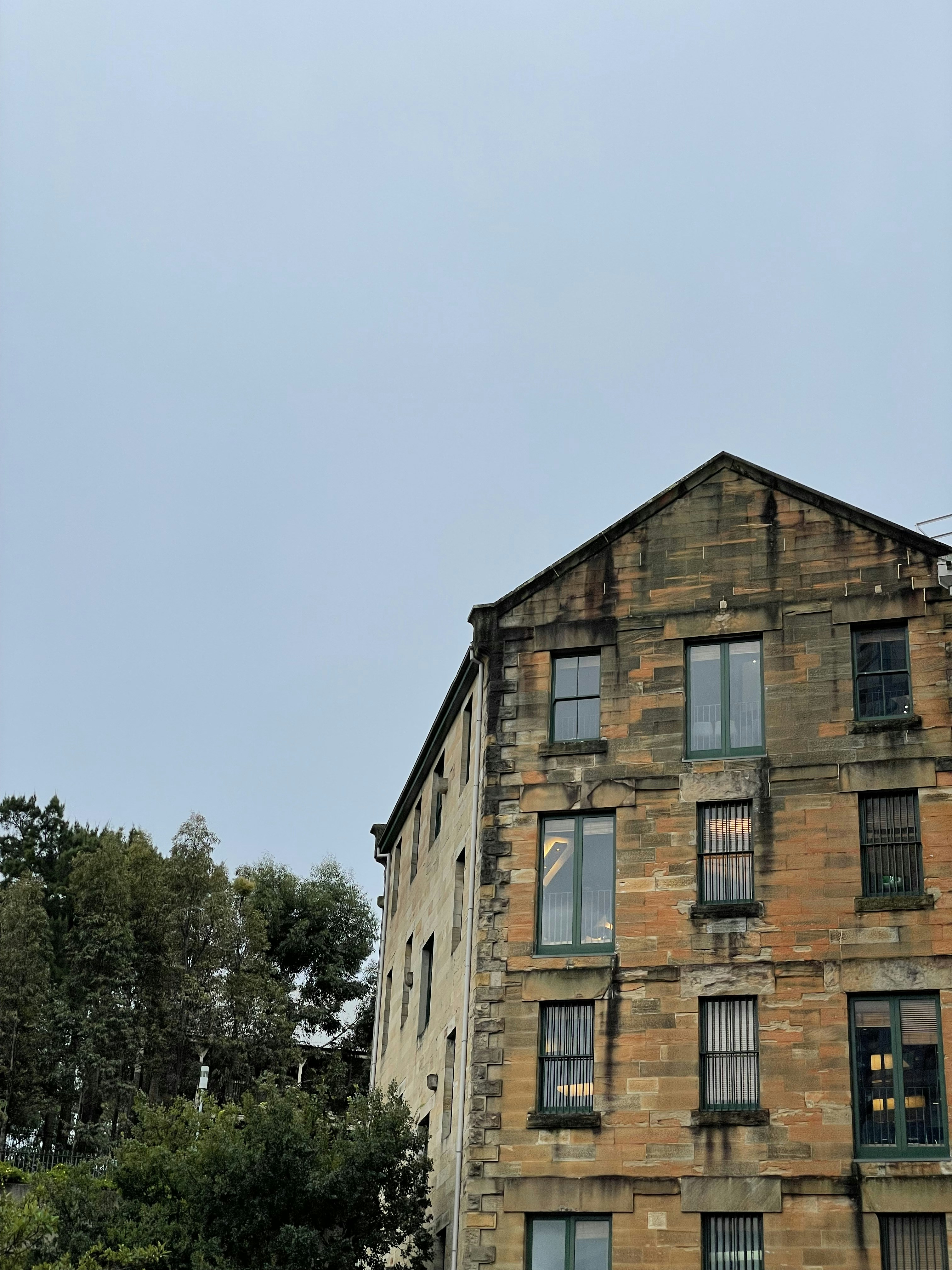 Weathered sandstone townhouse rising against a pale blue sky