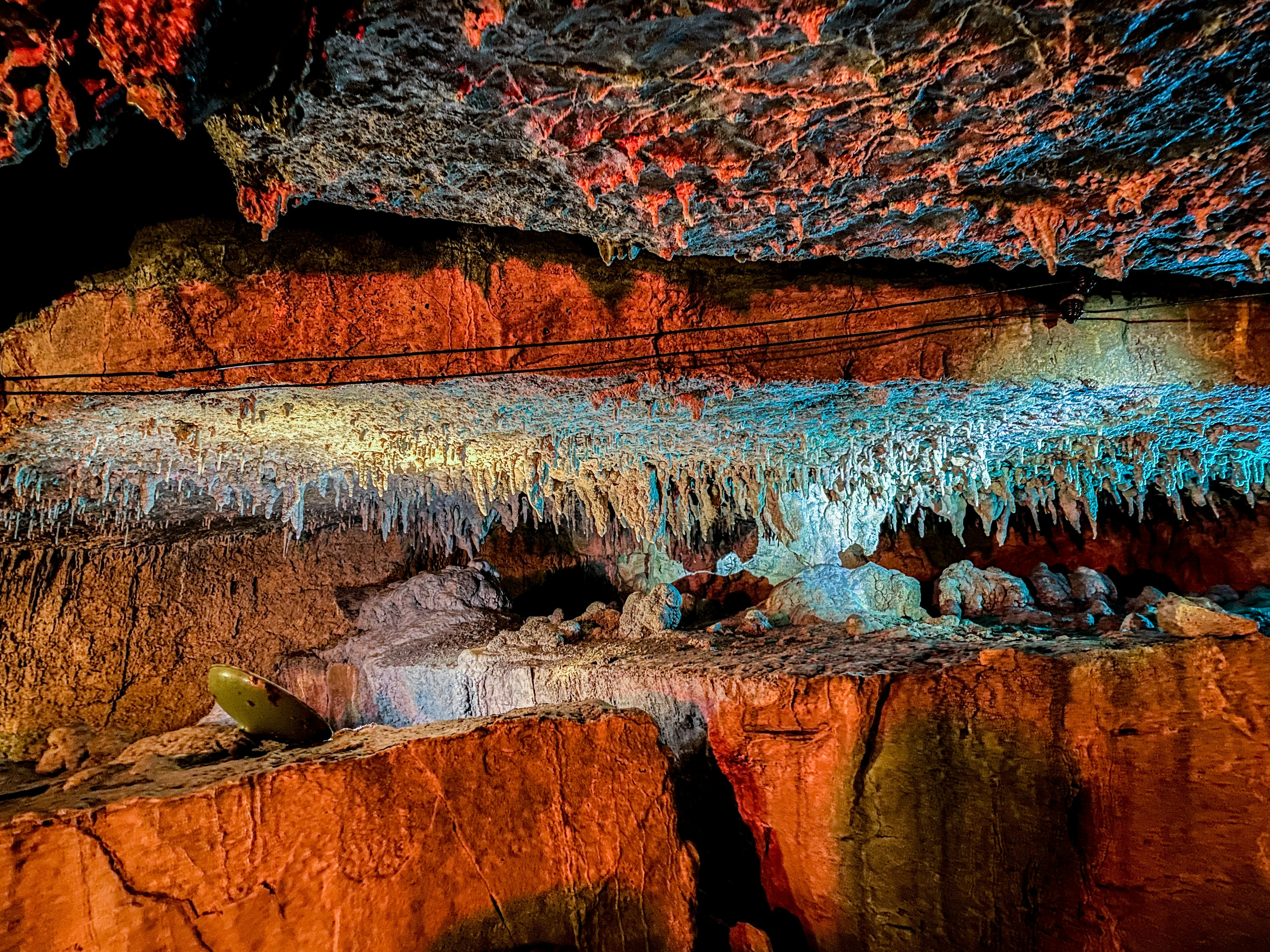 A rock wall with a blue and red rock formation photo – Free Cave Image ...
