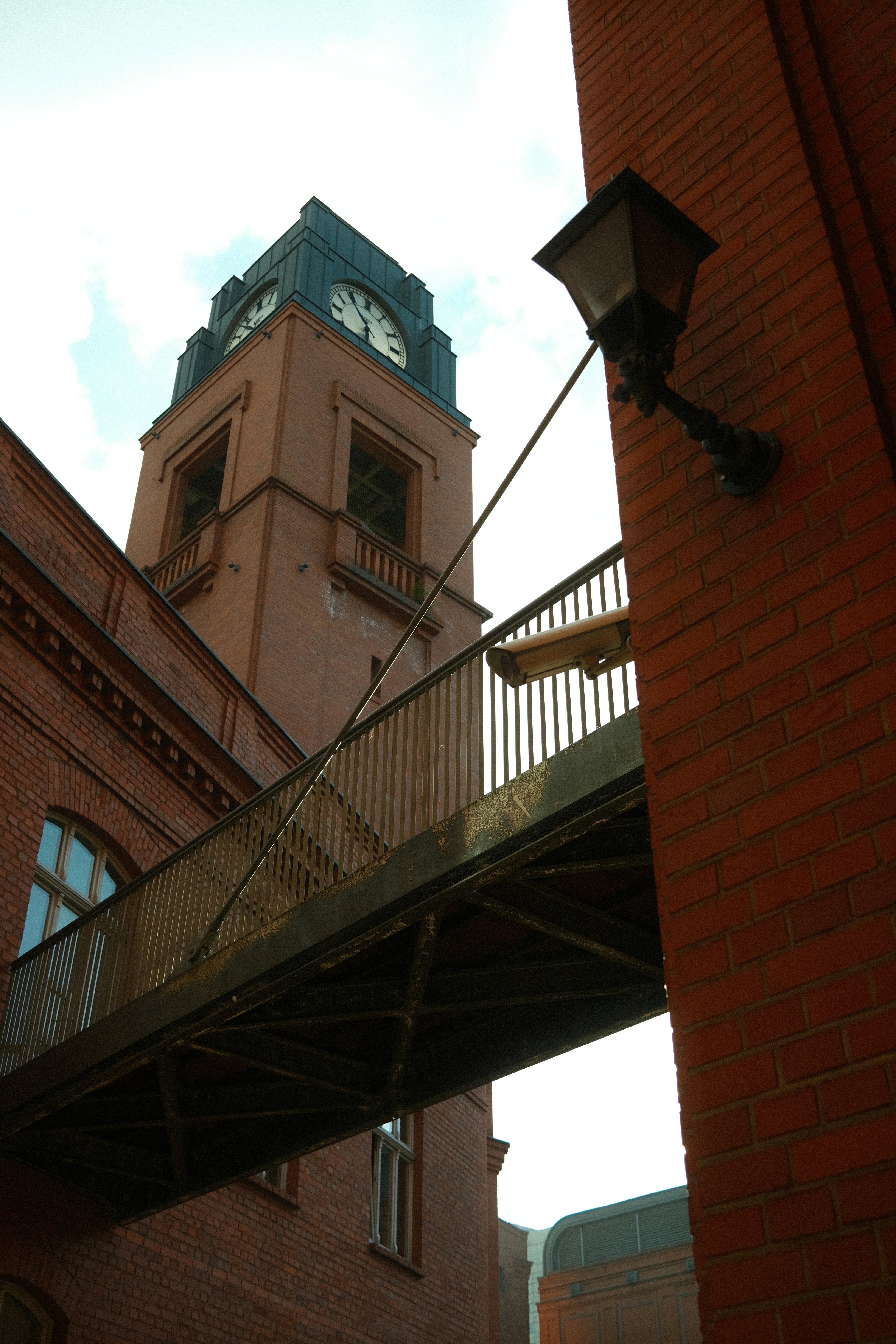 Clock Tower Rising Over a Weathered Brick Bridge