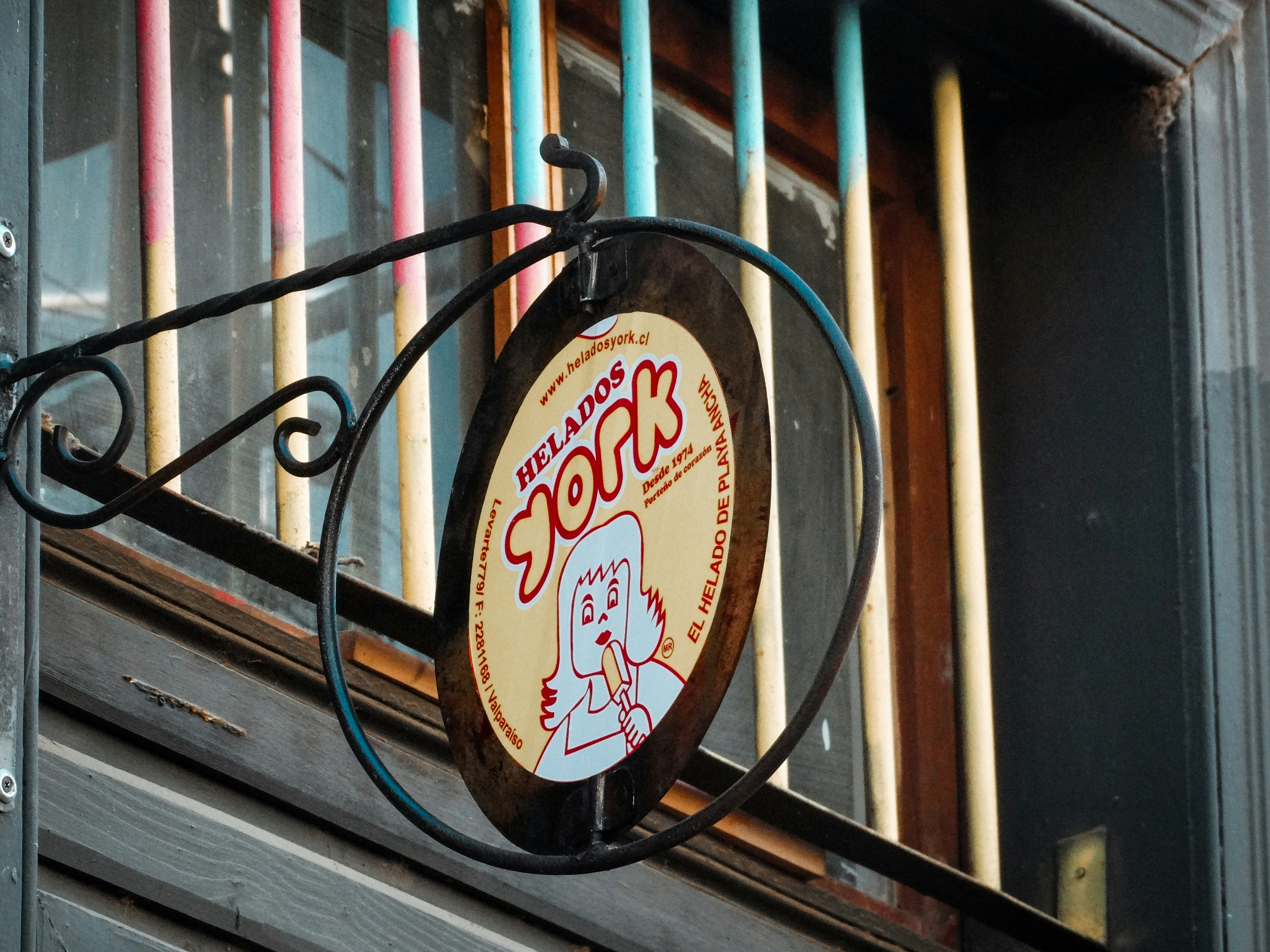 Ringed Logo of a Cartoon Chef Framed by Rainbow Window Bars