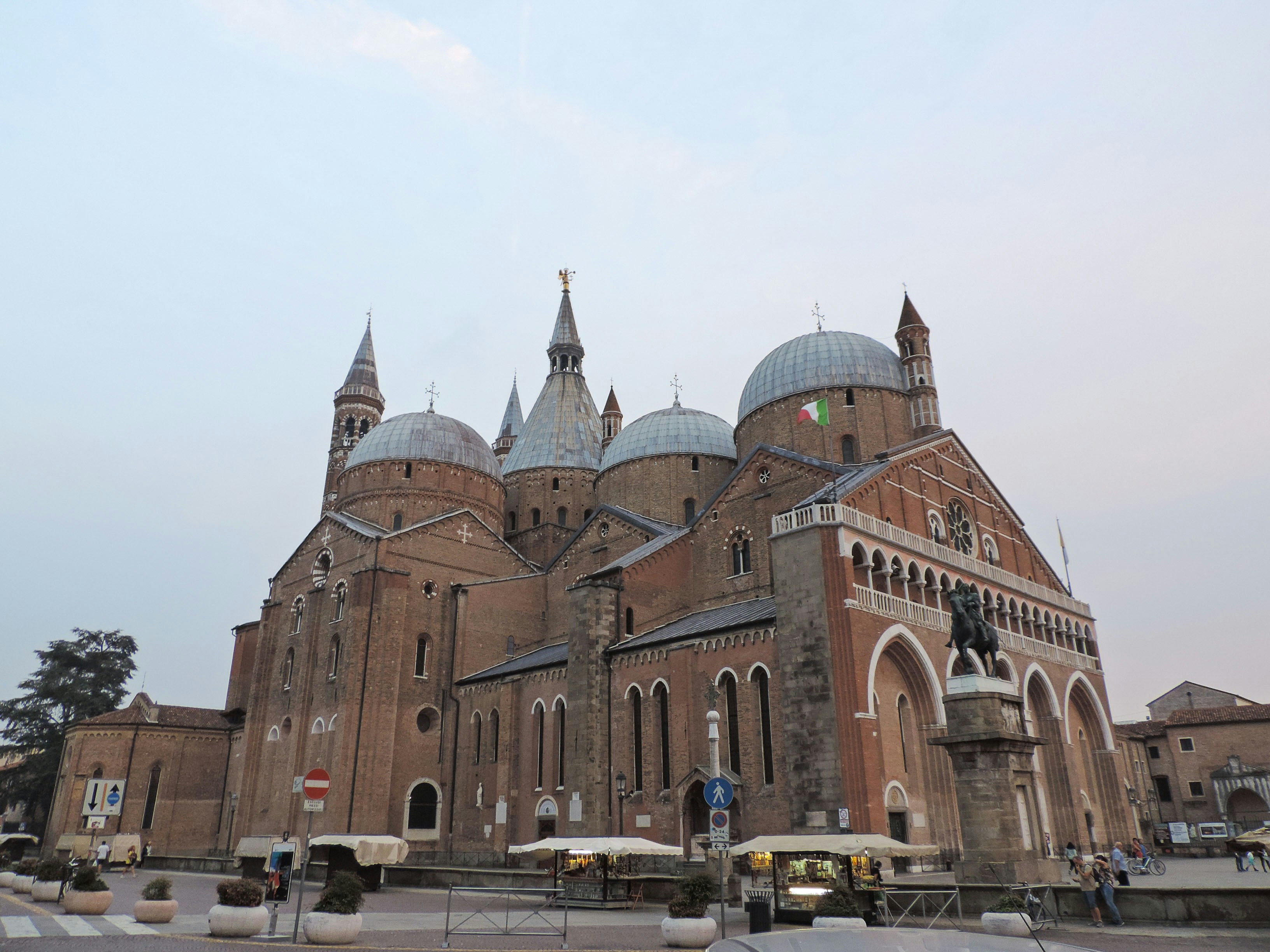 Historic basilica with multiple domes and a prominent statue in the foreground.