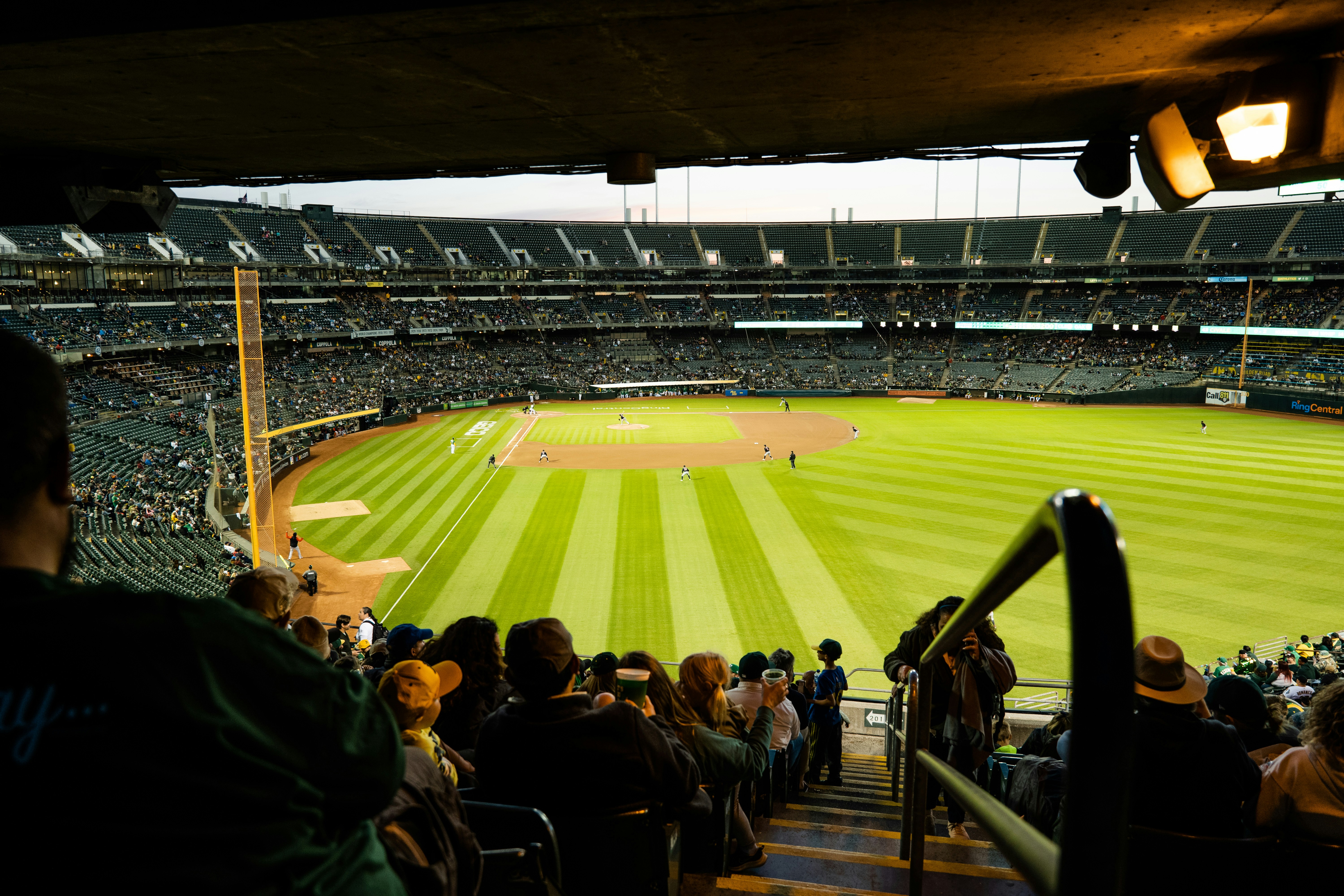 View from the stands capturing an empty baseball field, with spectators settling in as the game is about to begin.