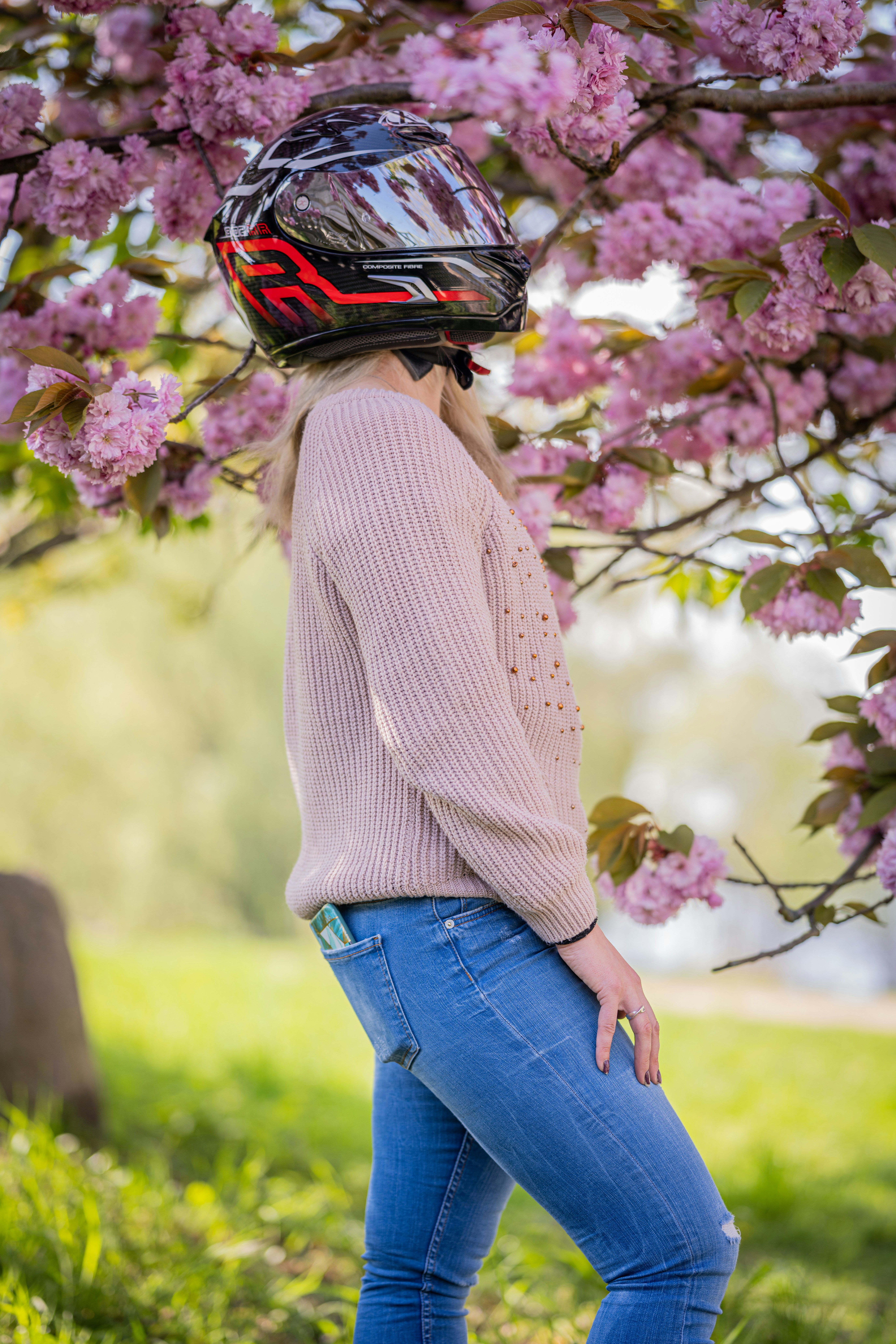 Under a Pink Cherry Canopy, a Helmeted Figure Pauses in Spring Light