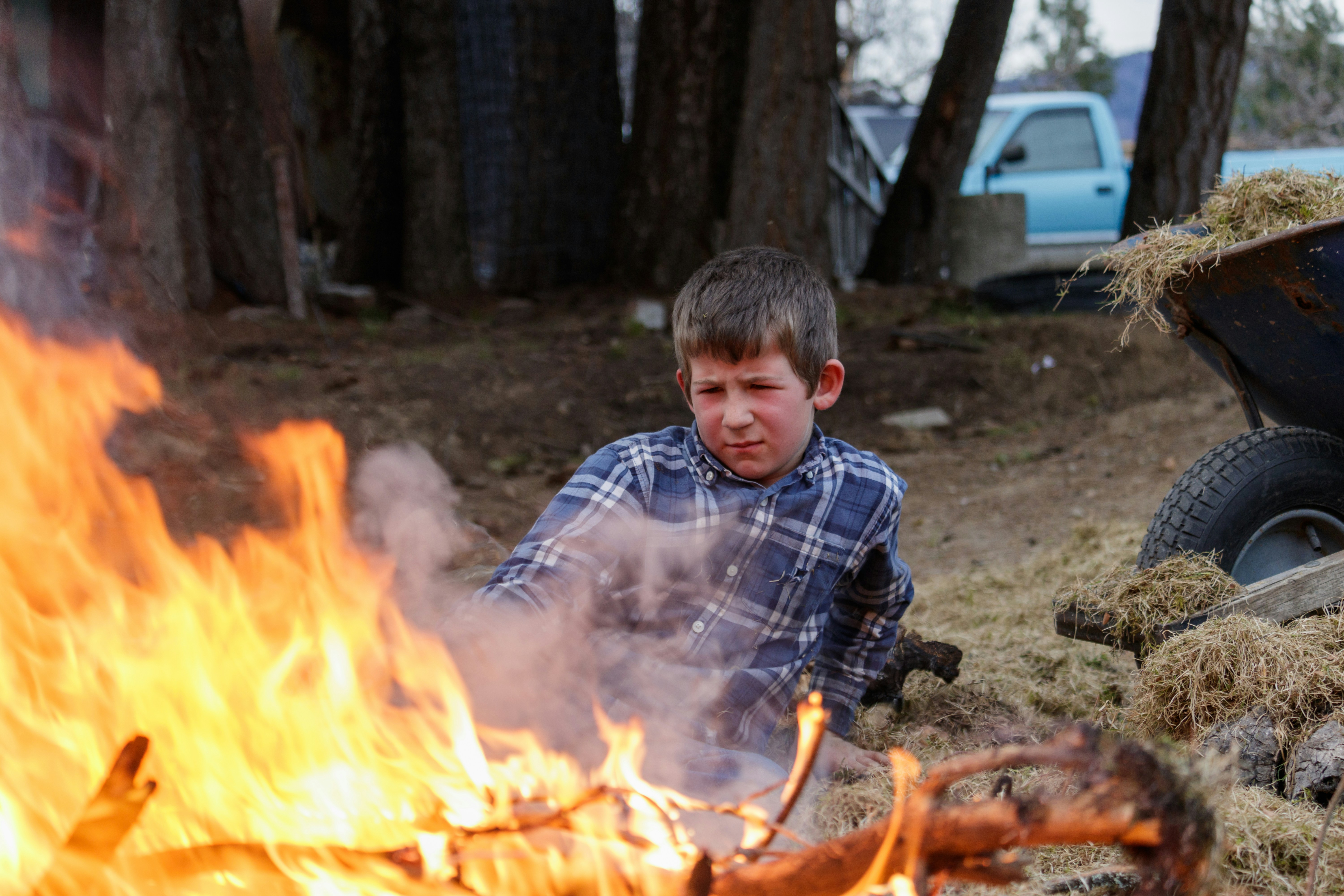 A boy sitting next to a fire photo – Free #flames Image on Unsplash