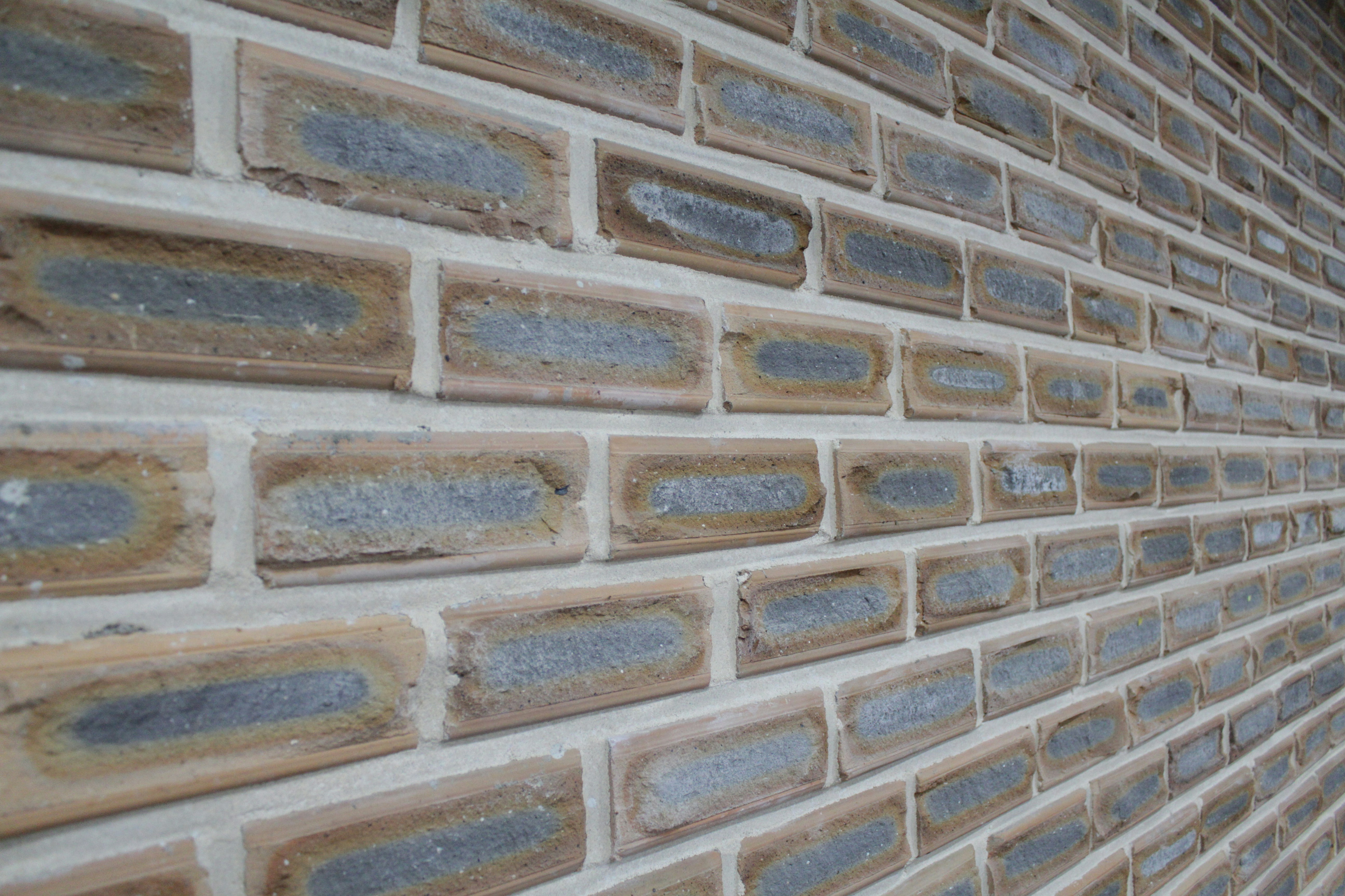 Close-up of a textured brick wall featuring alternating smooth and rough patterns, showcasing the craftsmanship in masonry.