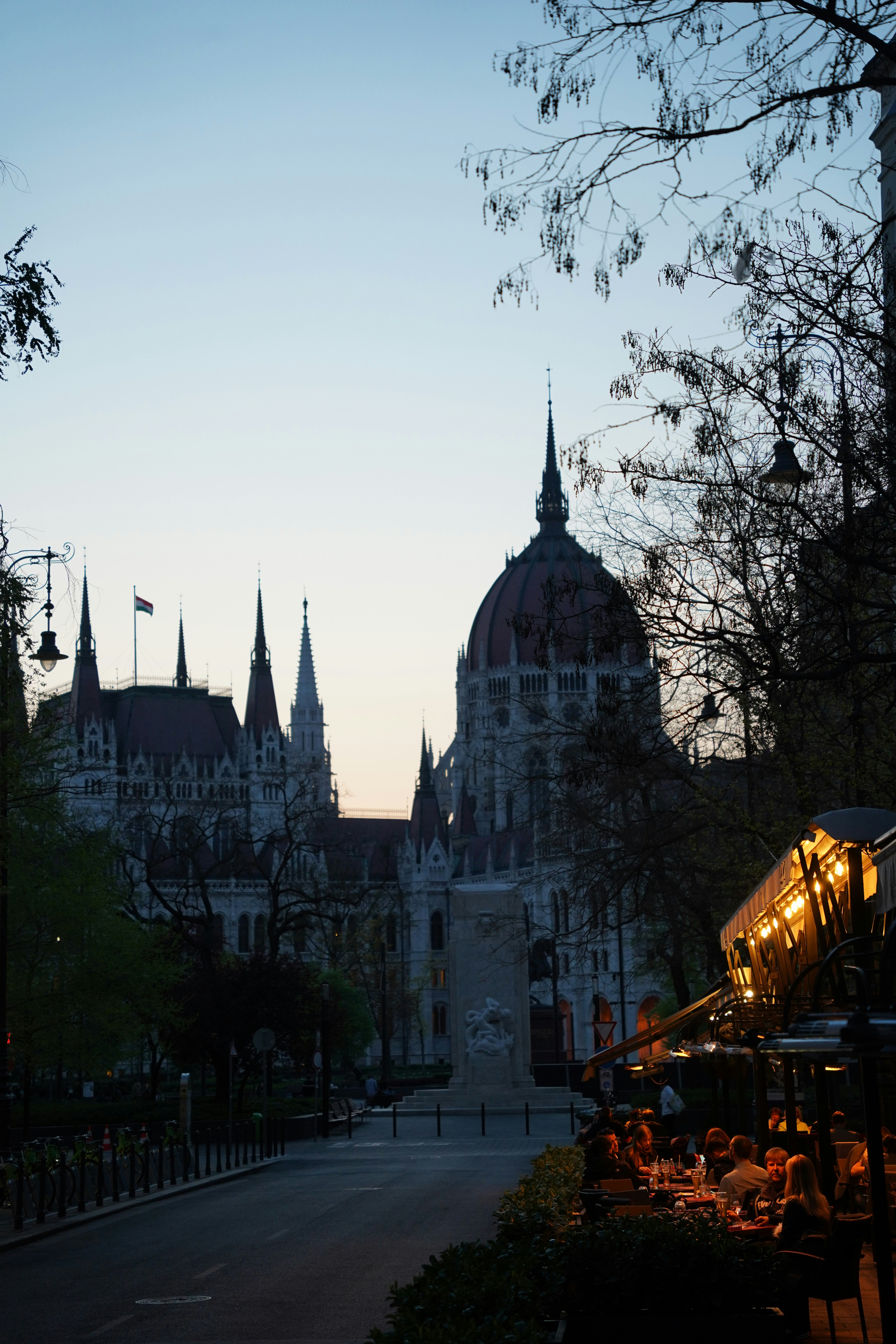 Dusk Between Spires: Café Glow by the Parliament's Dome