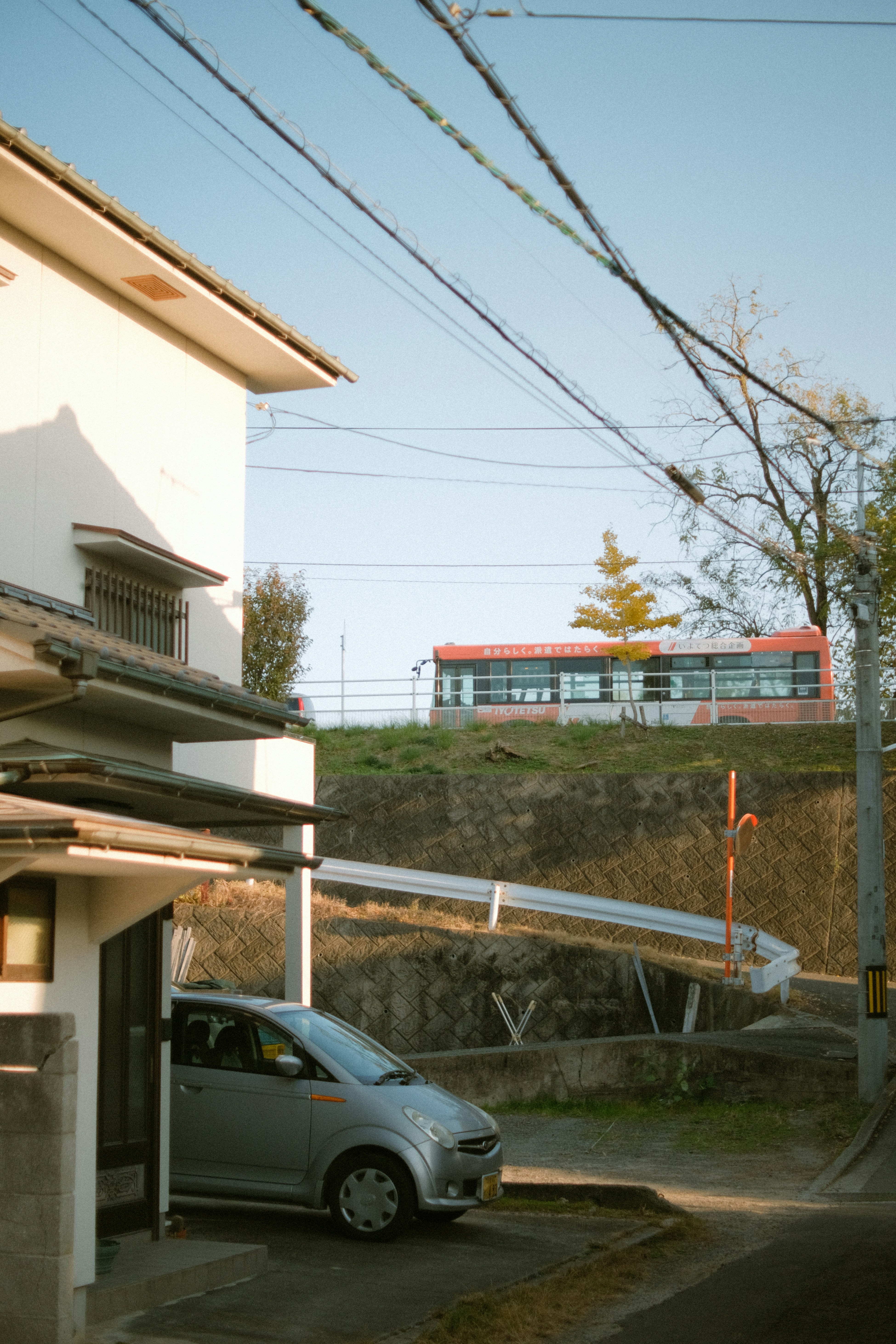 a car parked in front of a building with a train on the top
