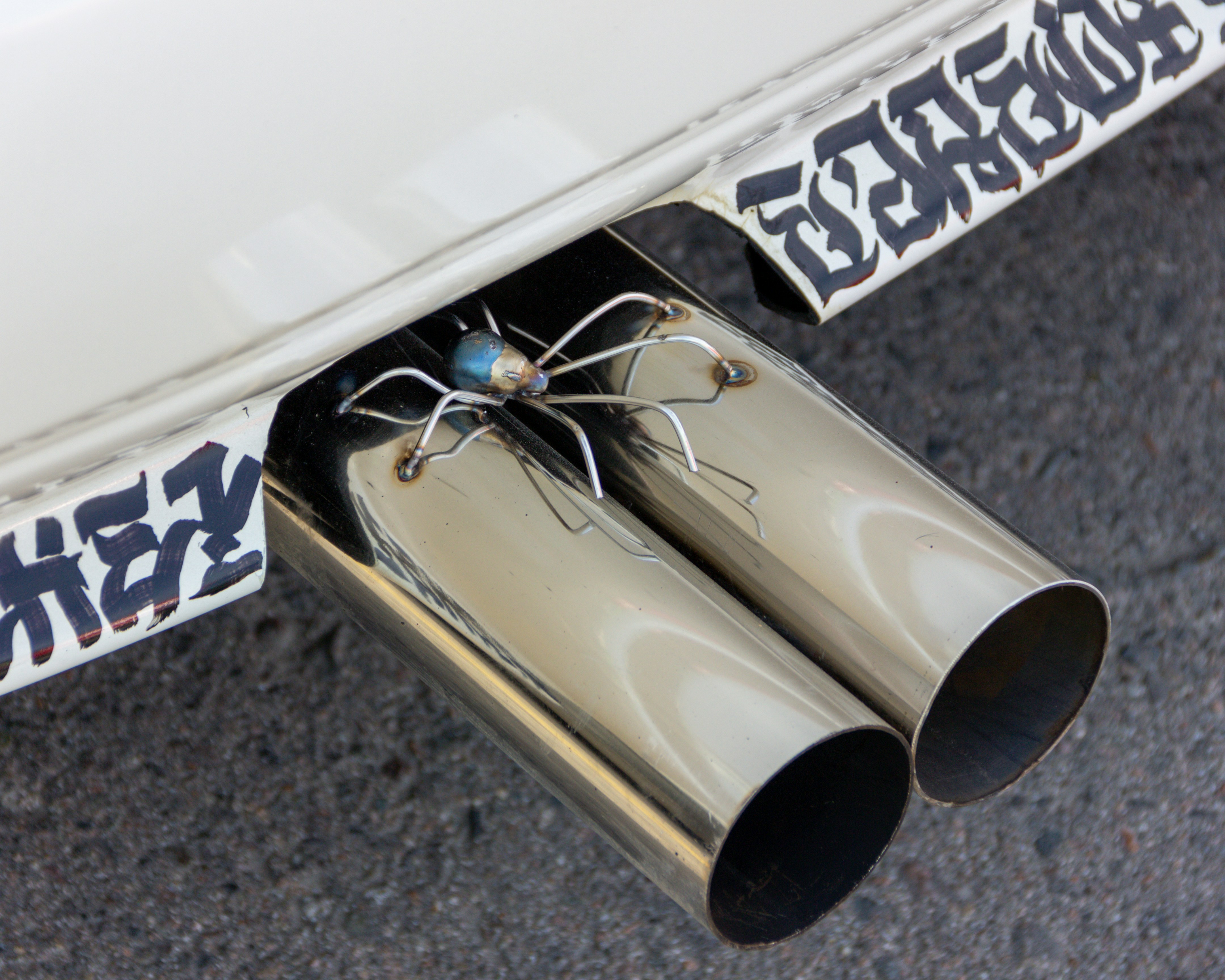Twin Chrome Exhausts Framed by Street Graffiti