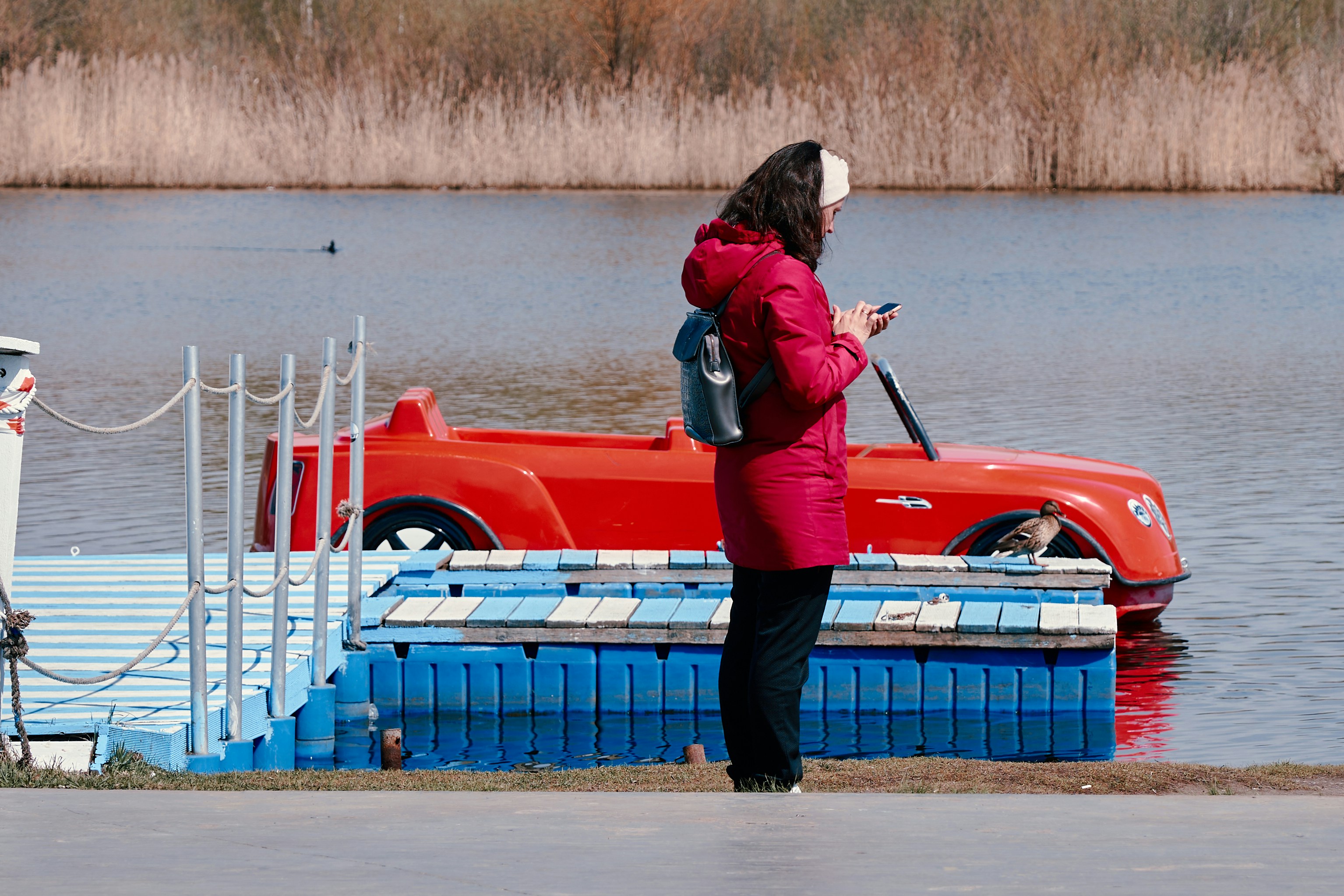 Crimson Coat by the Blue Dock: A Quiet Moment with a Red Vintage Convertible