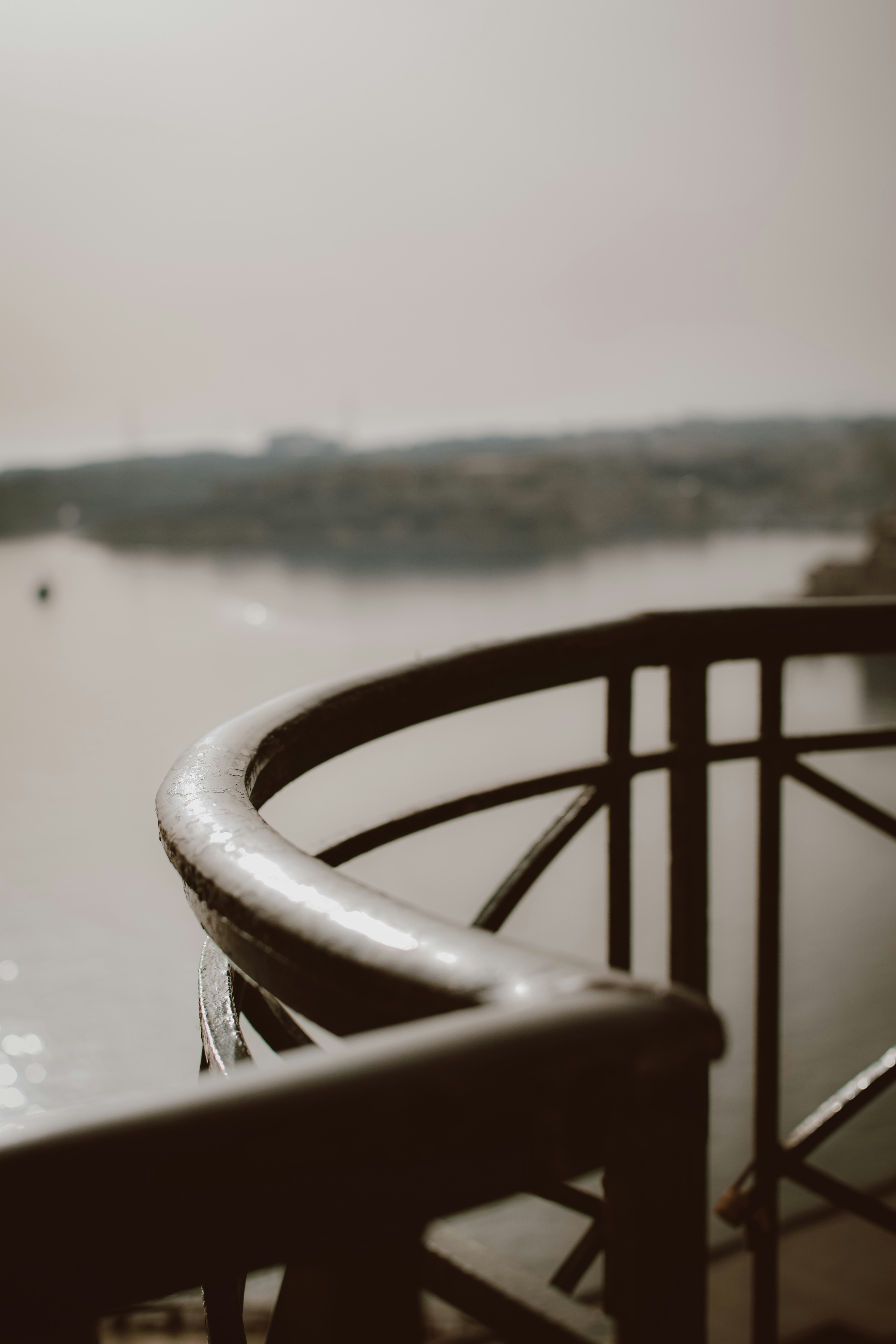 Rimmed Quiet: A Circular Railing Framing a Misty Riverside