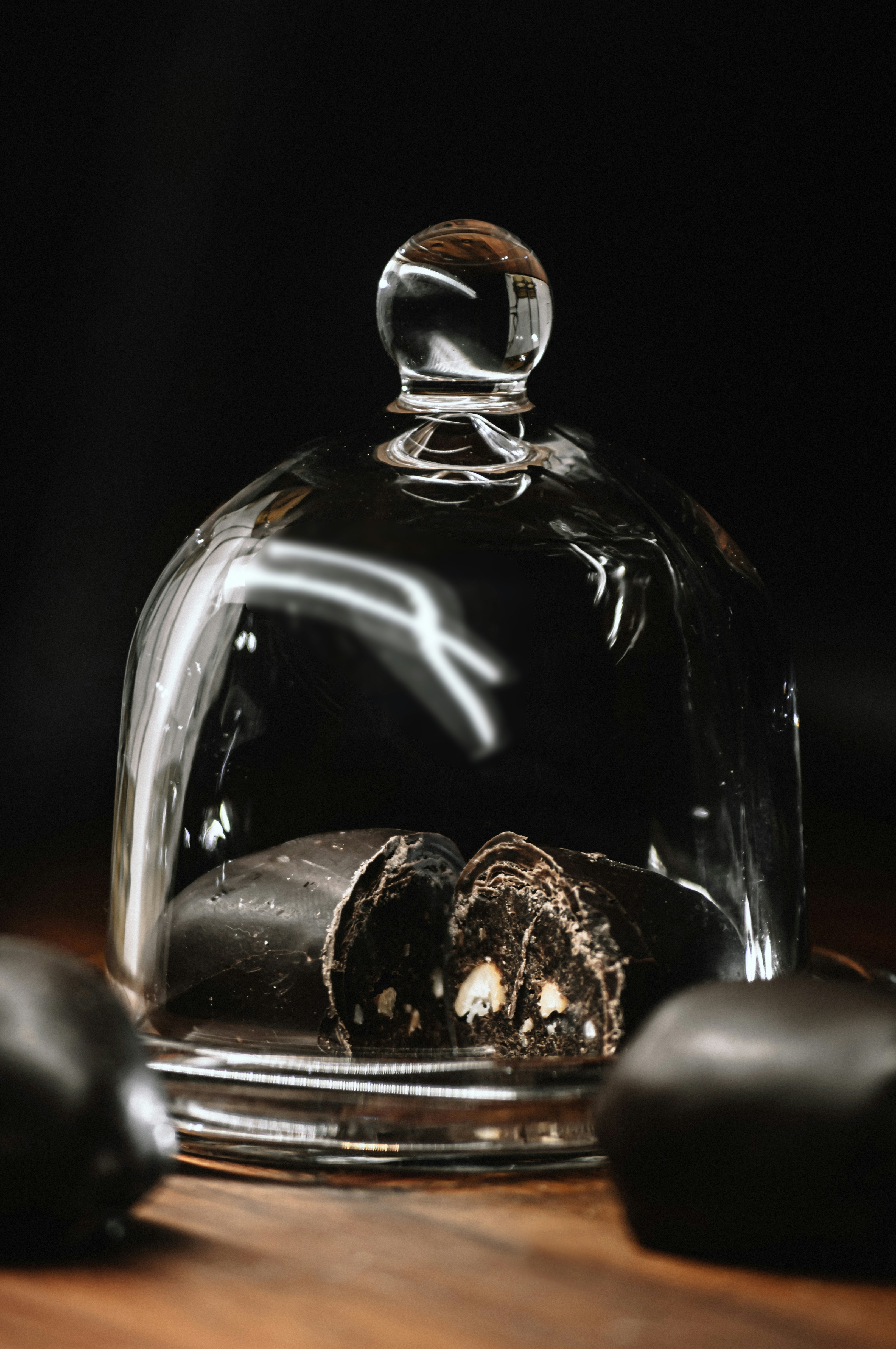 Under Glass Bell: Two Dark Truffles Rest in Velvet Shadow