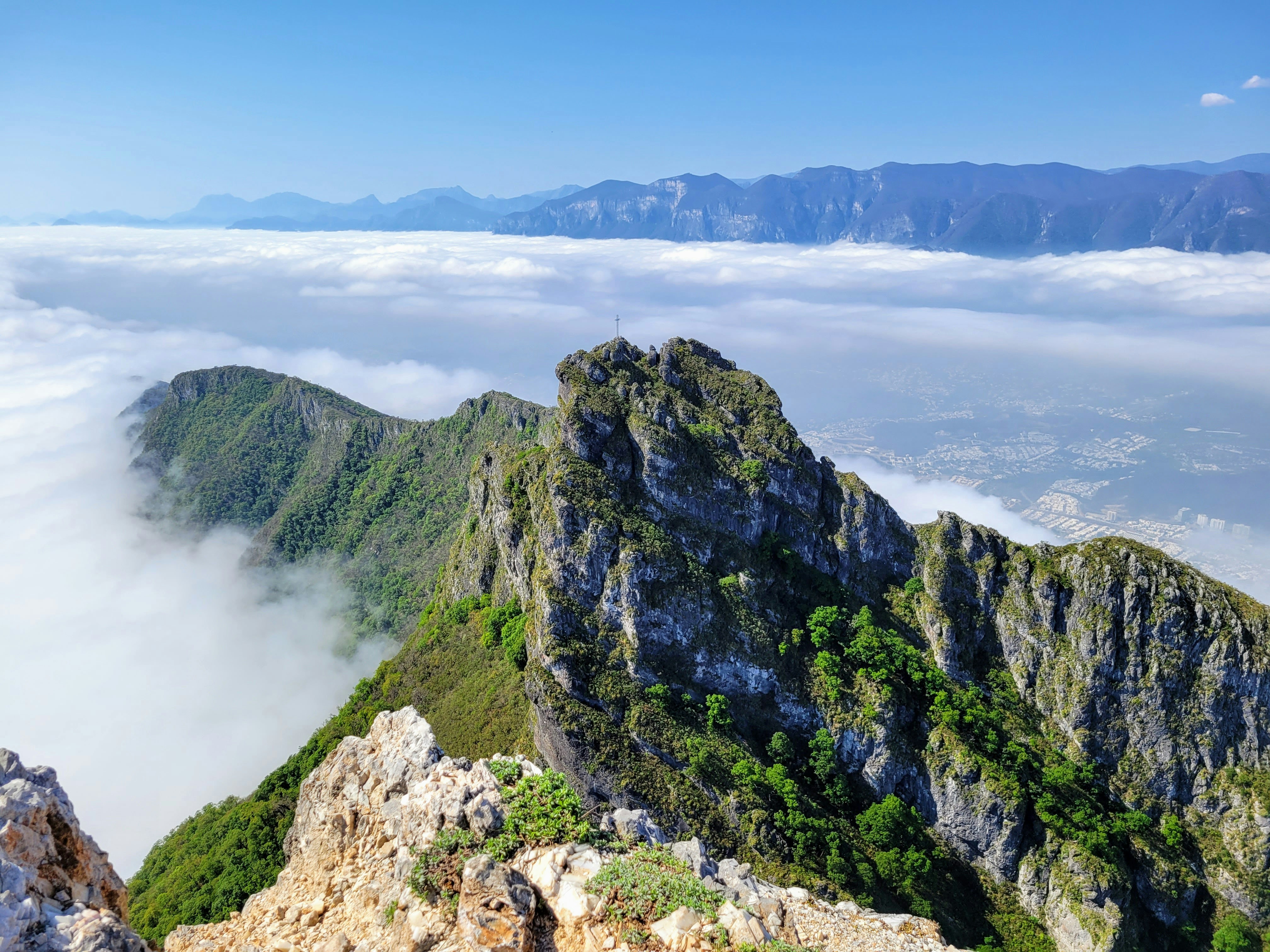 a mountain with clouds below