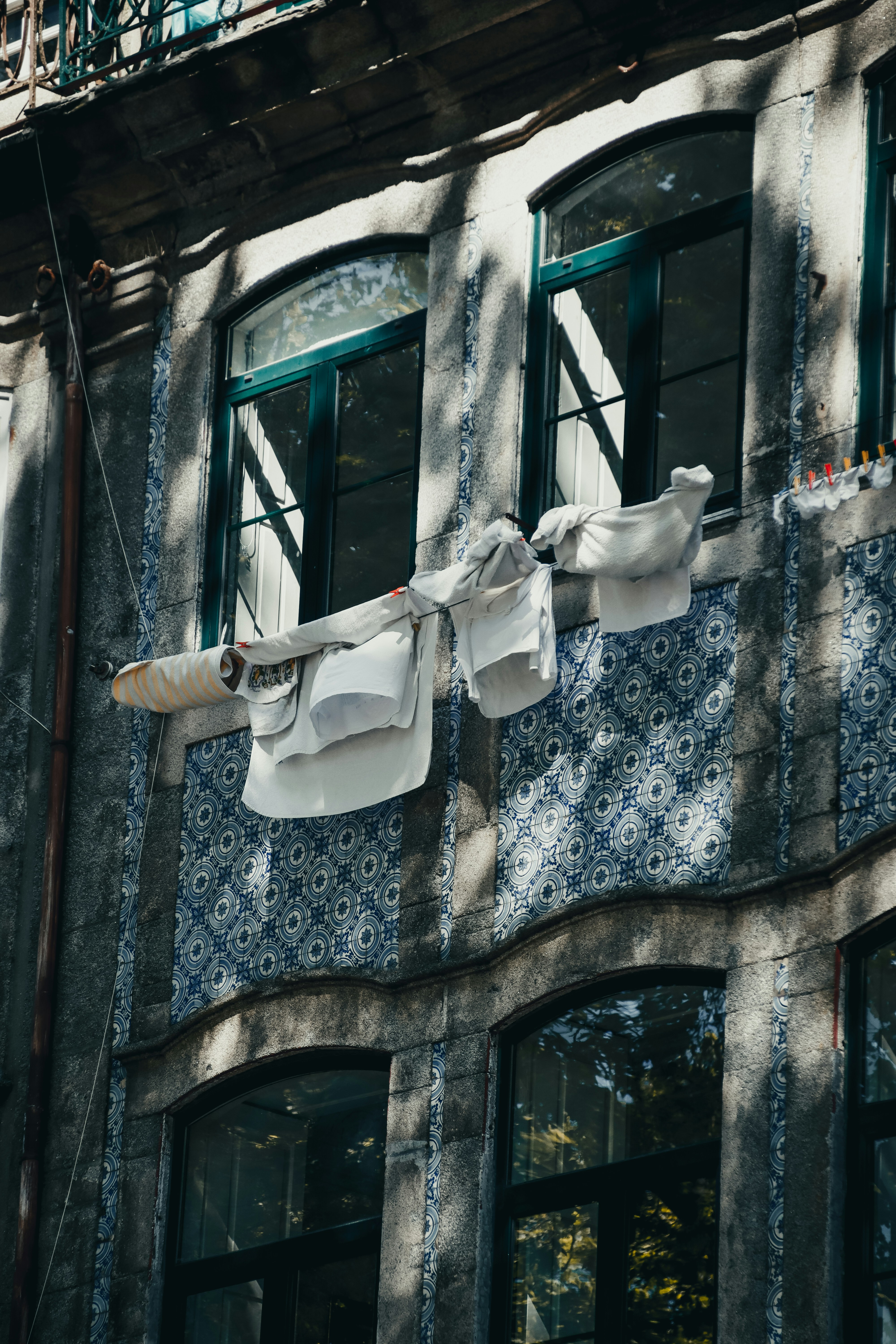White Laundry on a Weathered Azulejo Facade under Dappled Light