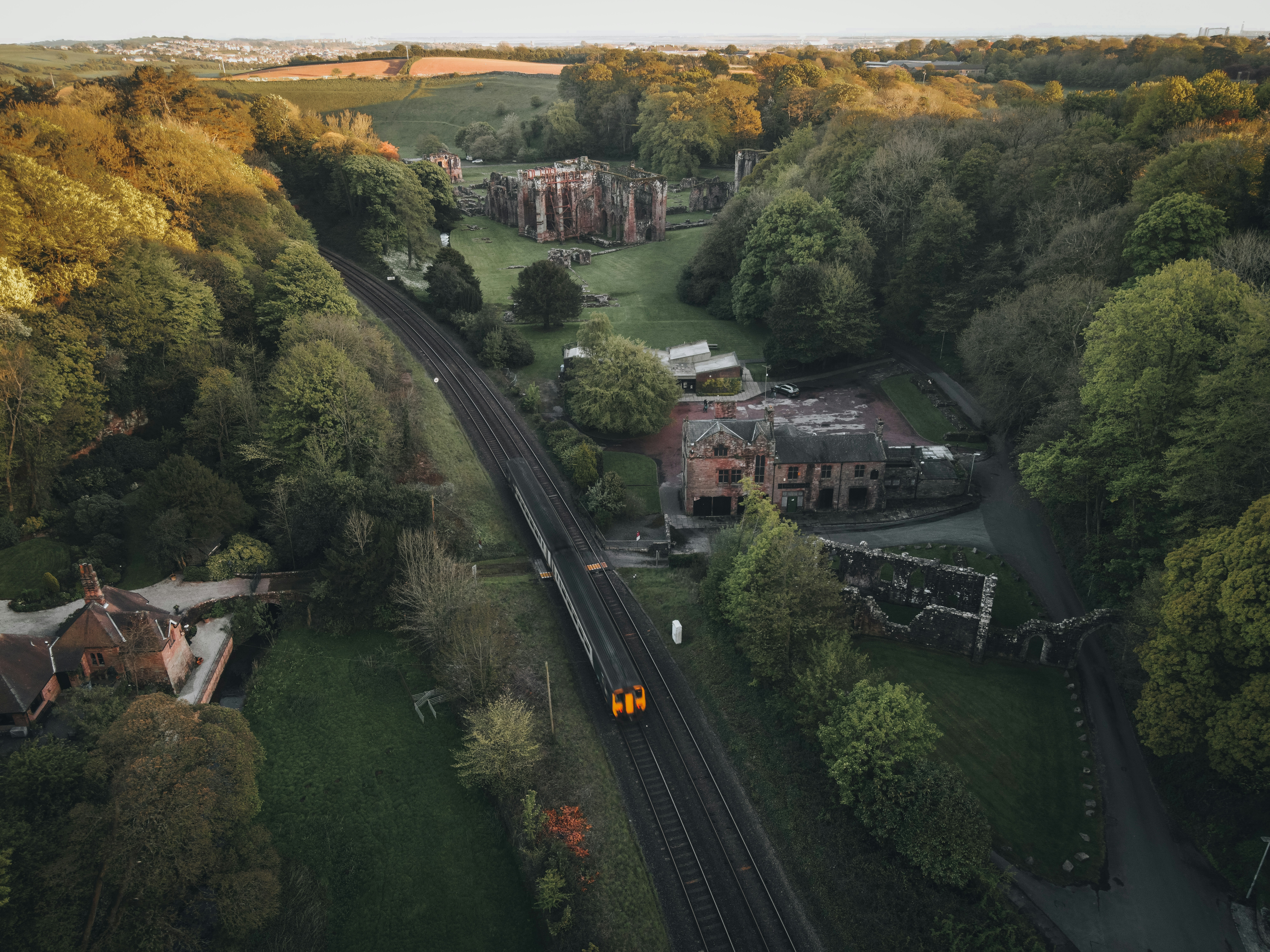 Autumn Rails: Aerial View of a Winding Track Through a Historic Estate
