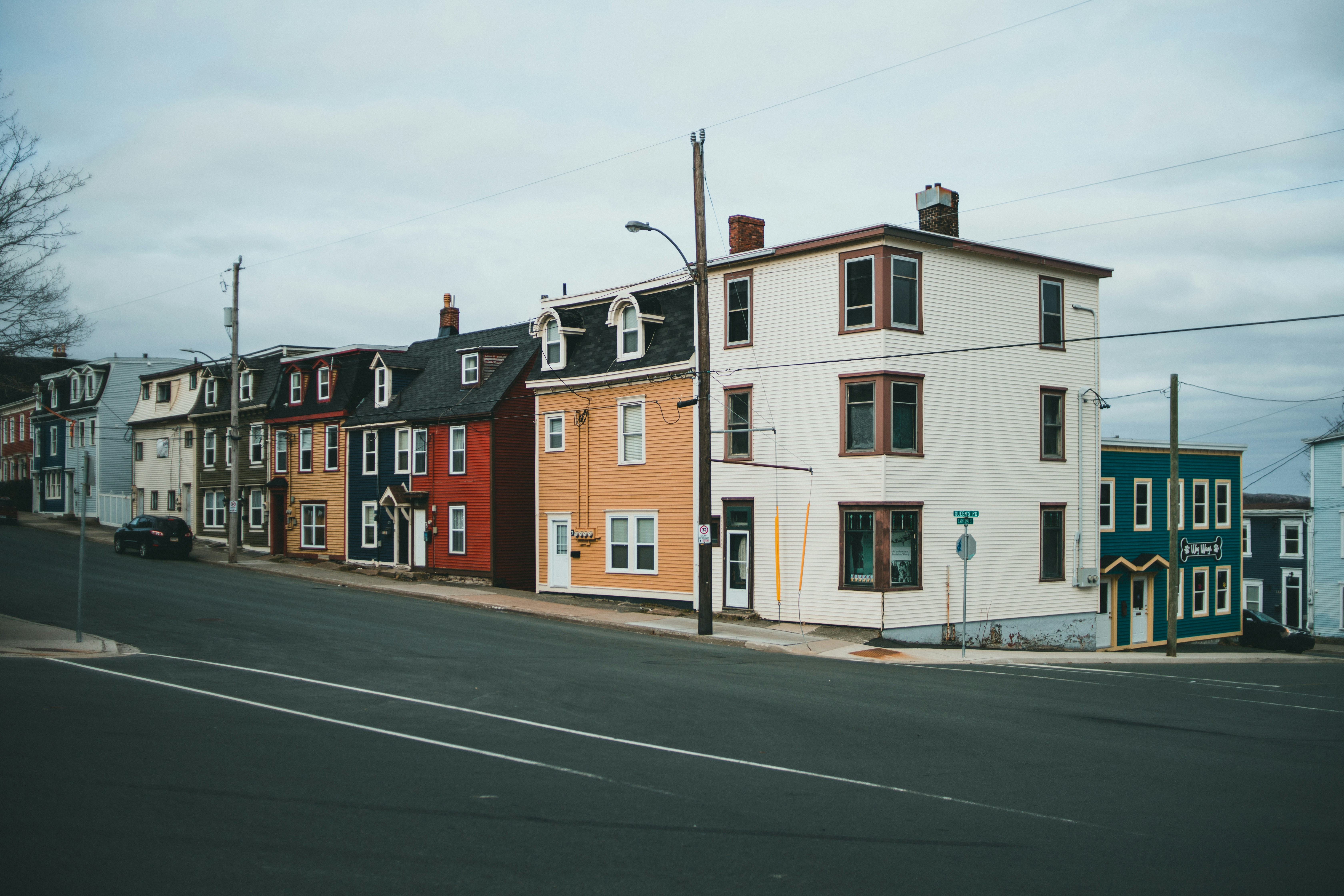 Cornerhouse Glow: Pastel Row Along a Quiet, Sloped Street