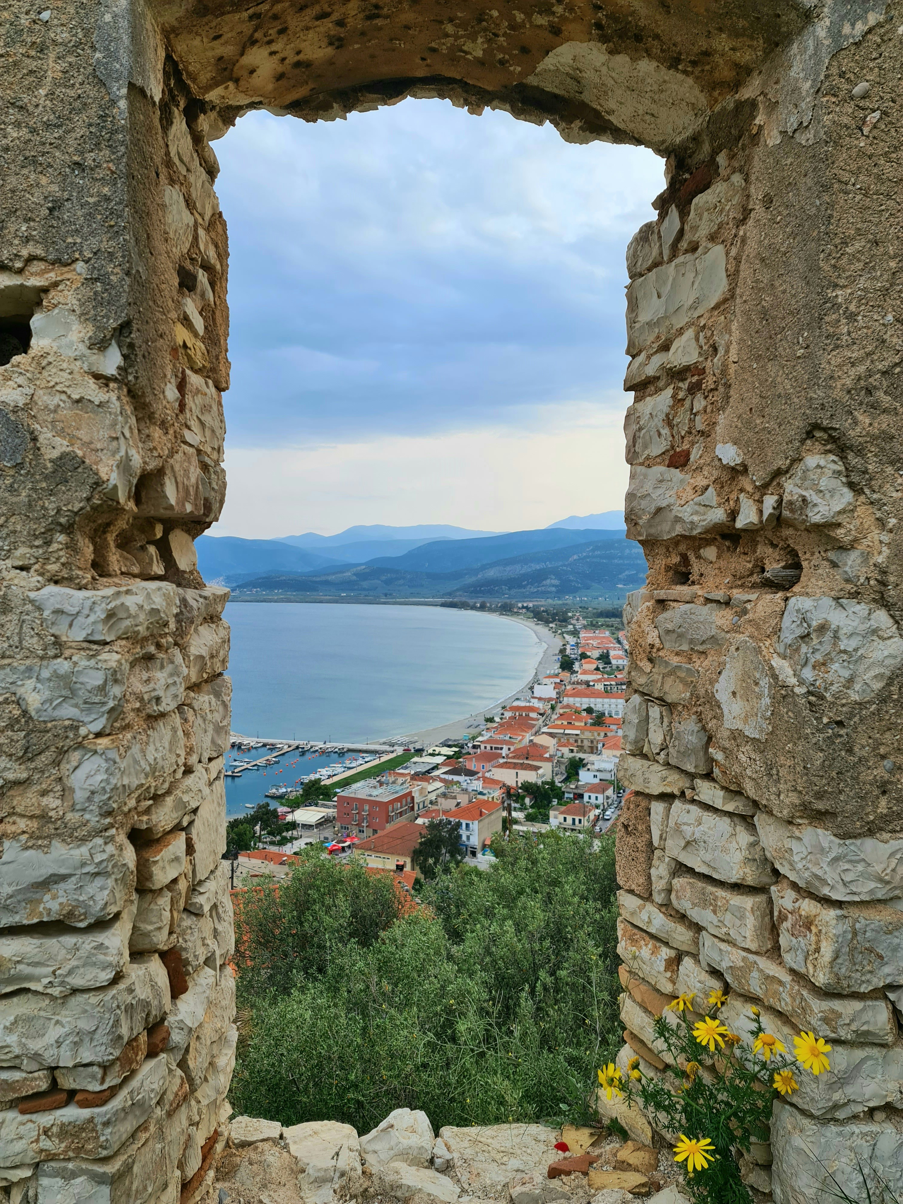 Through Weathered Arches, a Coastal Town Unfolds Along the Bay