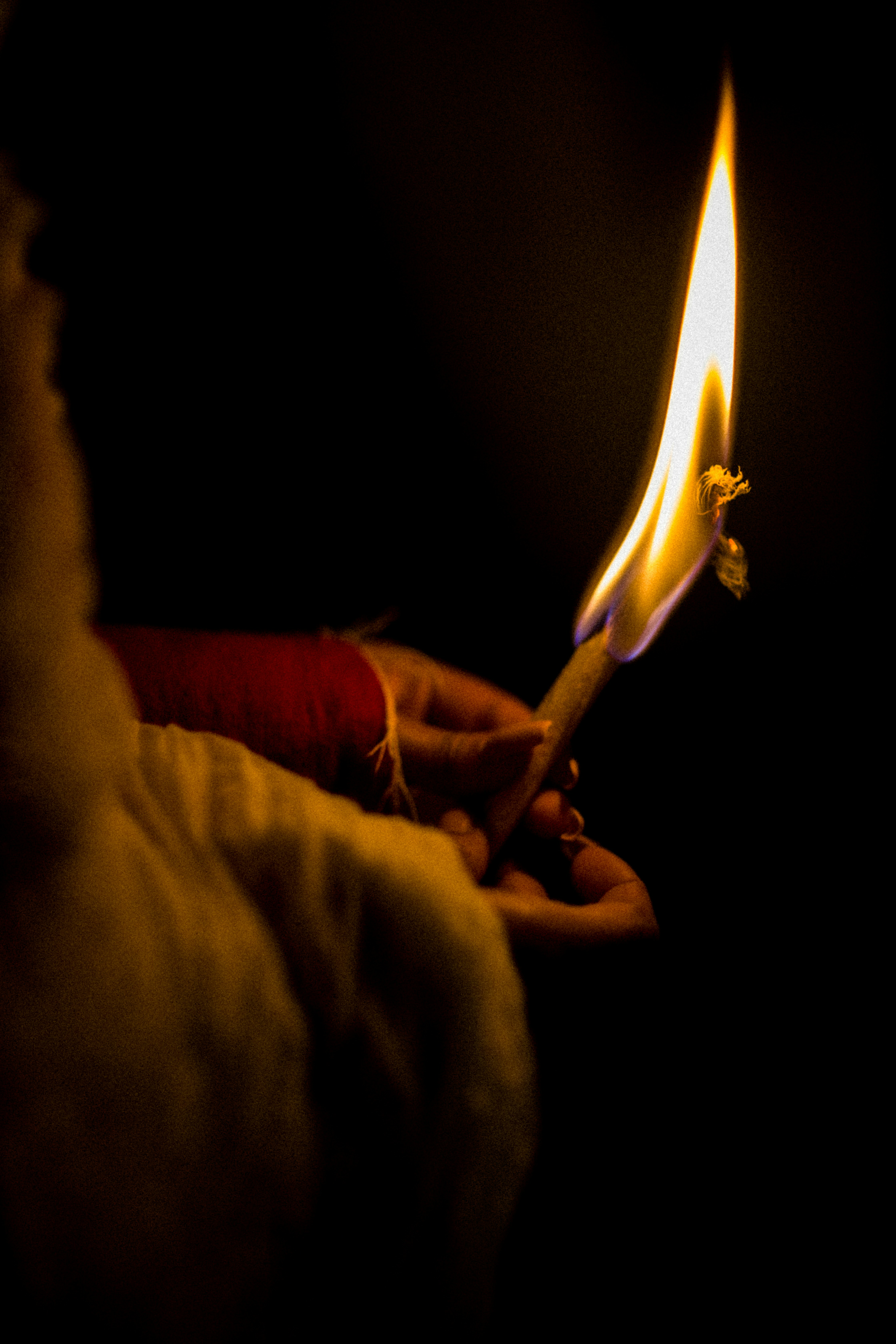 Ceremonial Flame: A single candle held aloft in near-darkness