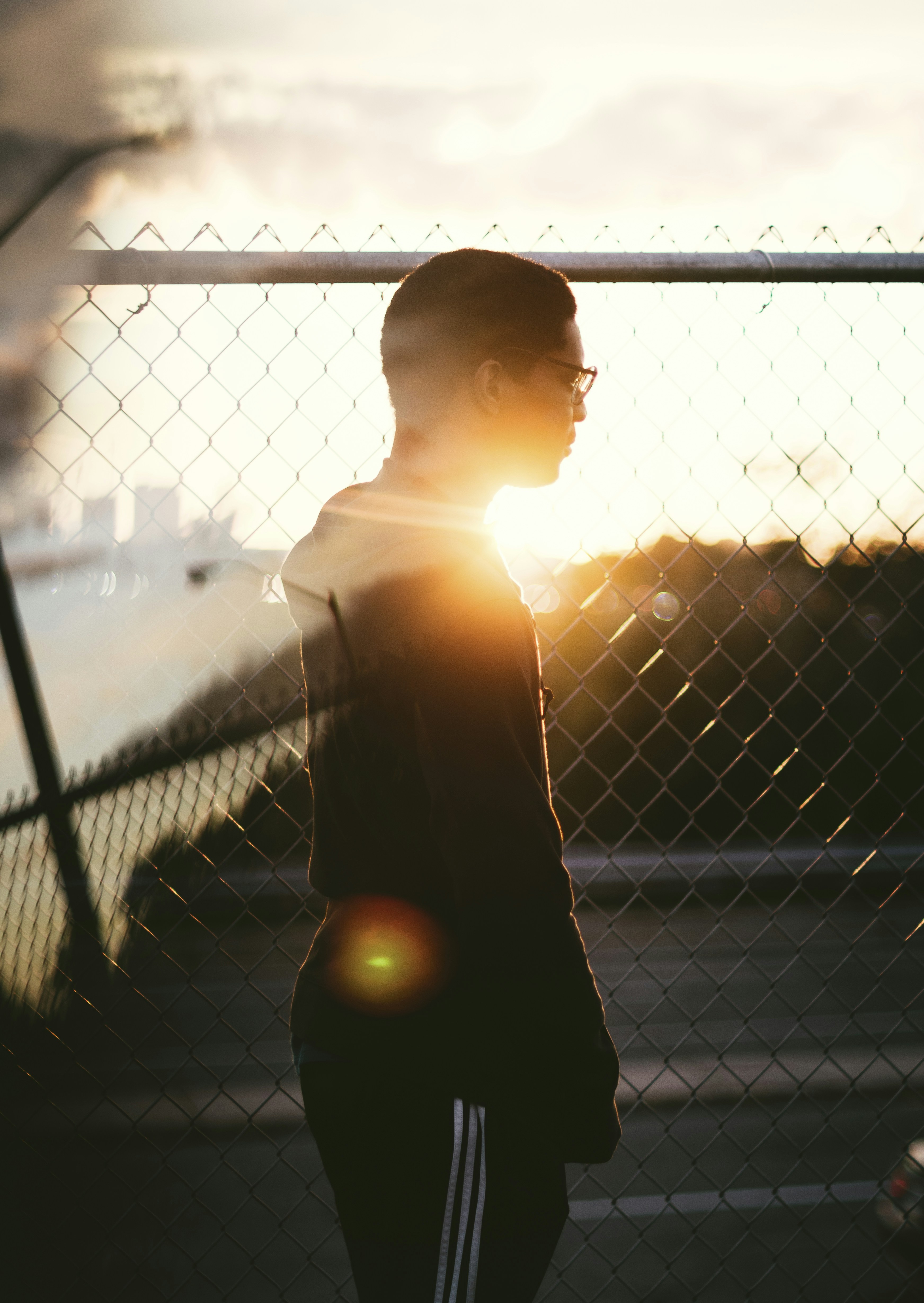 A person standing in front of a fence photo – Free Portrait Image on ...