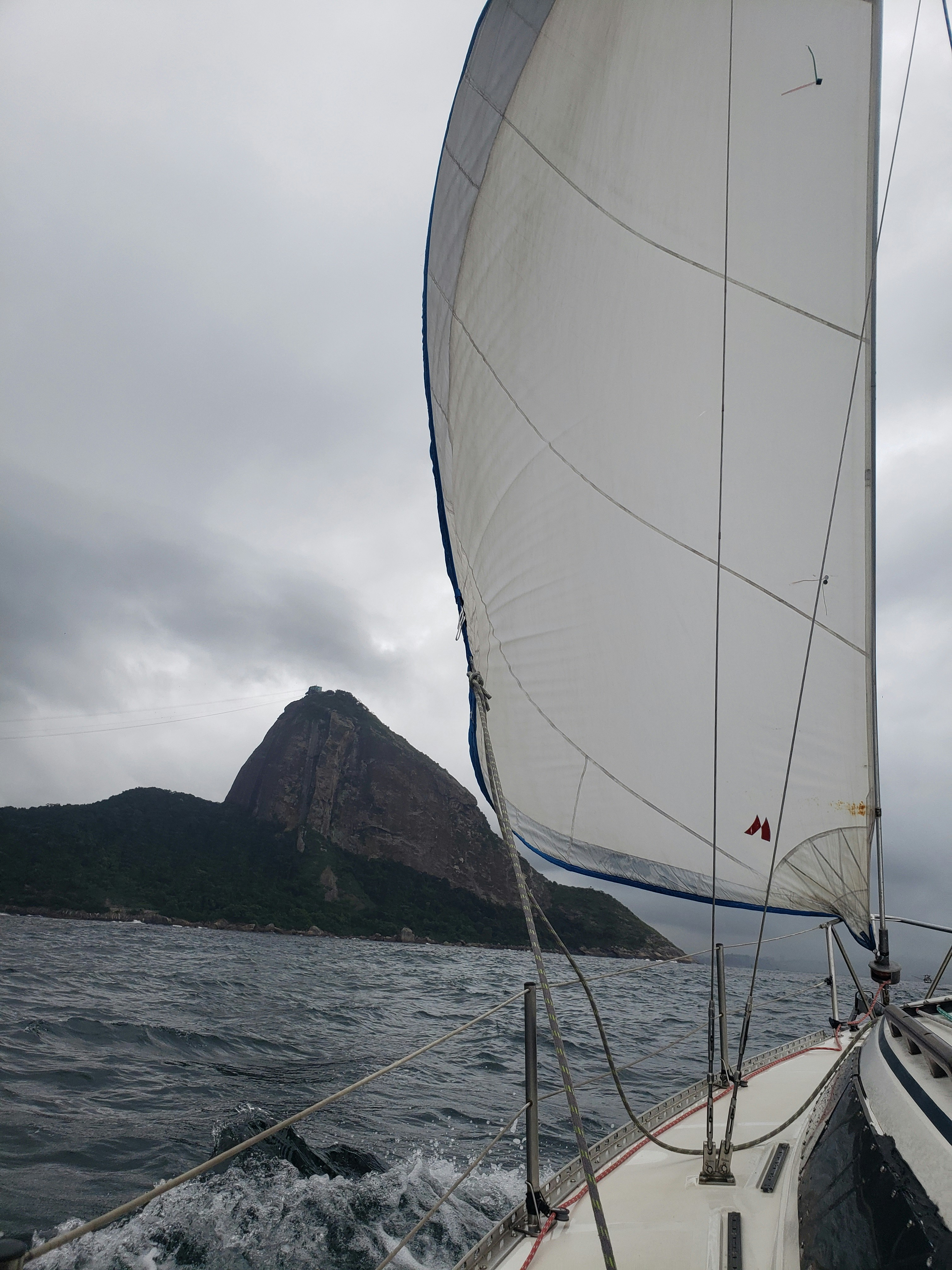 Broad Sails, Rugged Horizon: A Sailboat Skims Toward a Granite Isle
