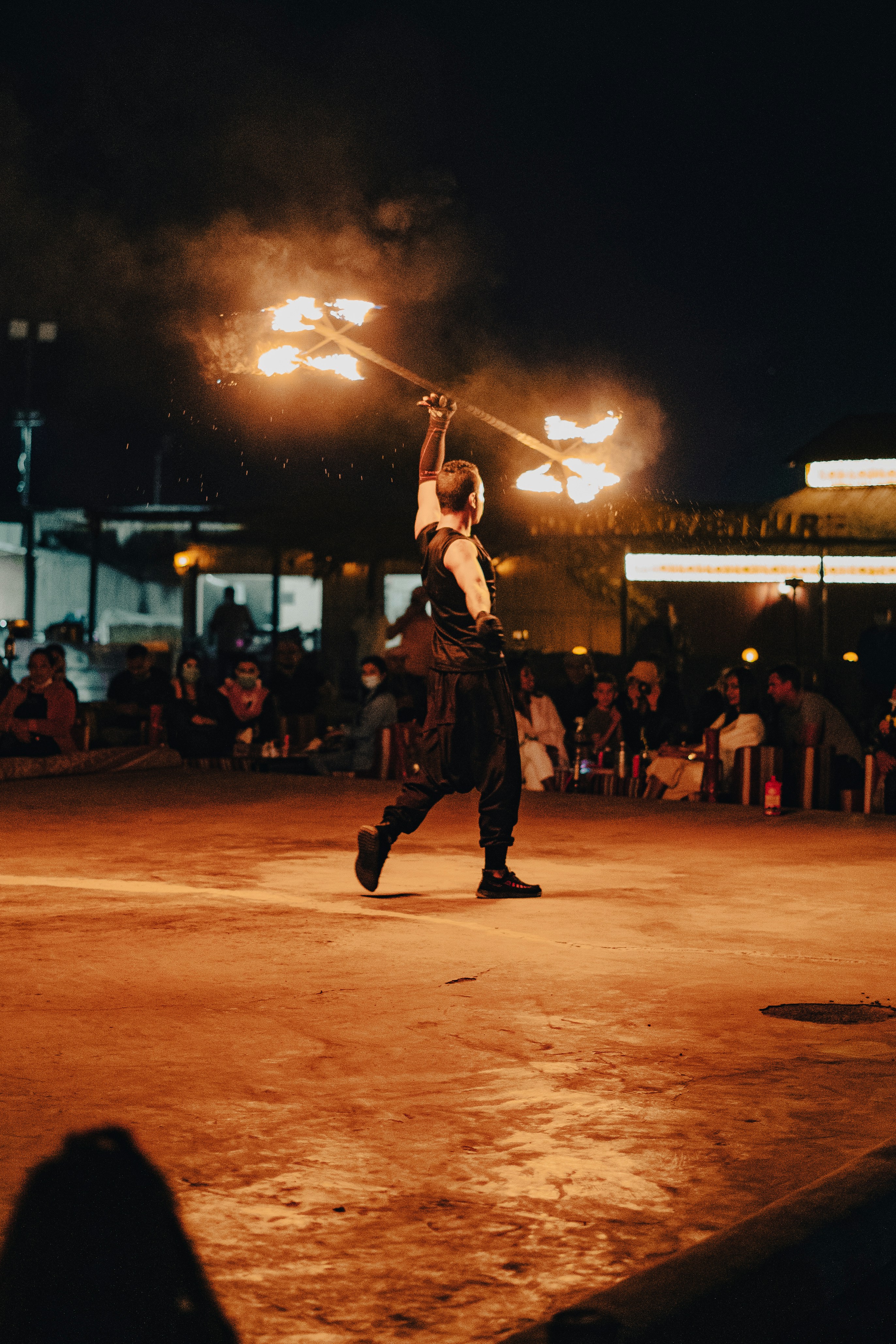 a man holding a stick with fire in the air
