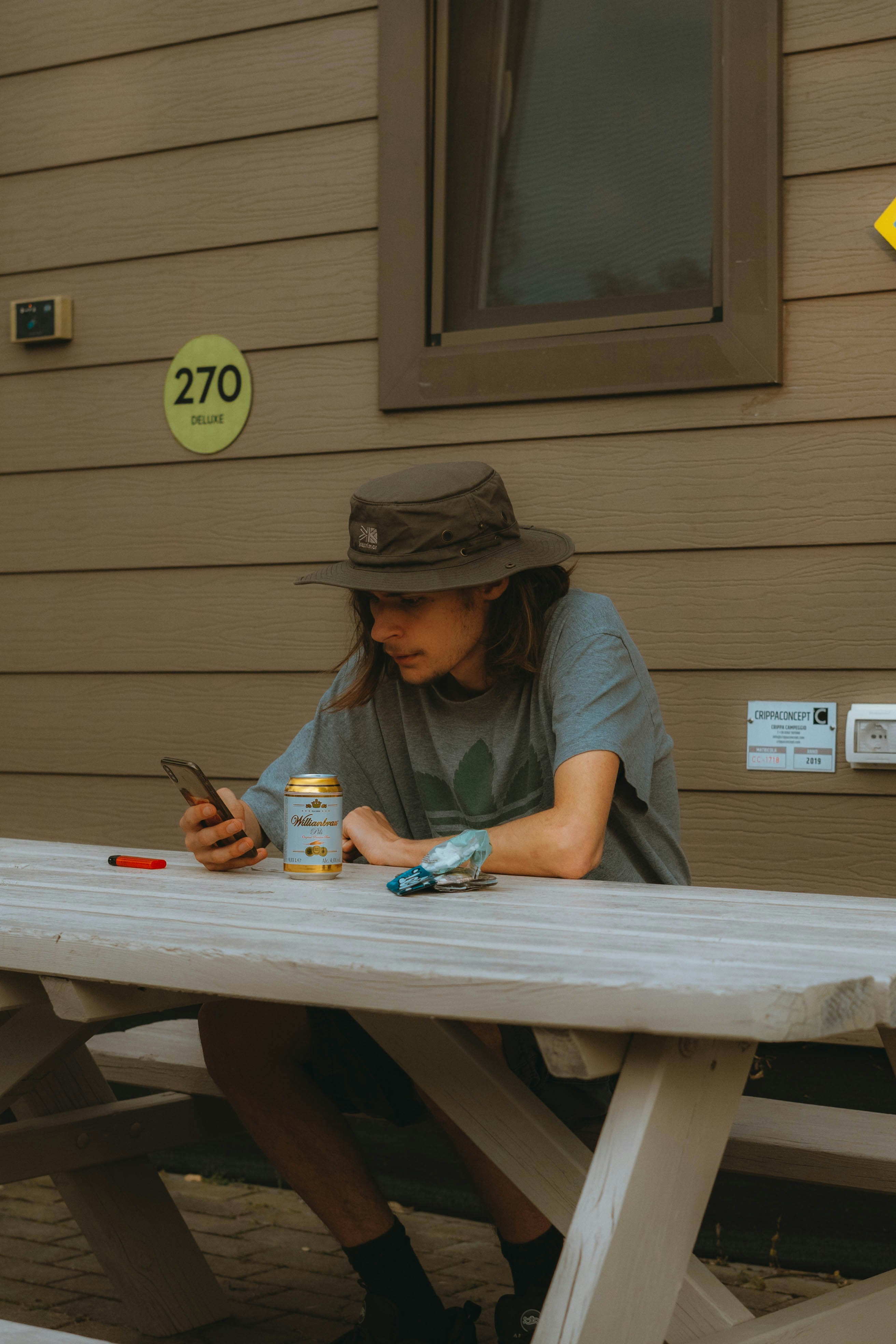 Outdoor cafe Scholar: a lone companion with phone and can