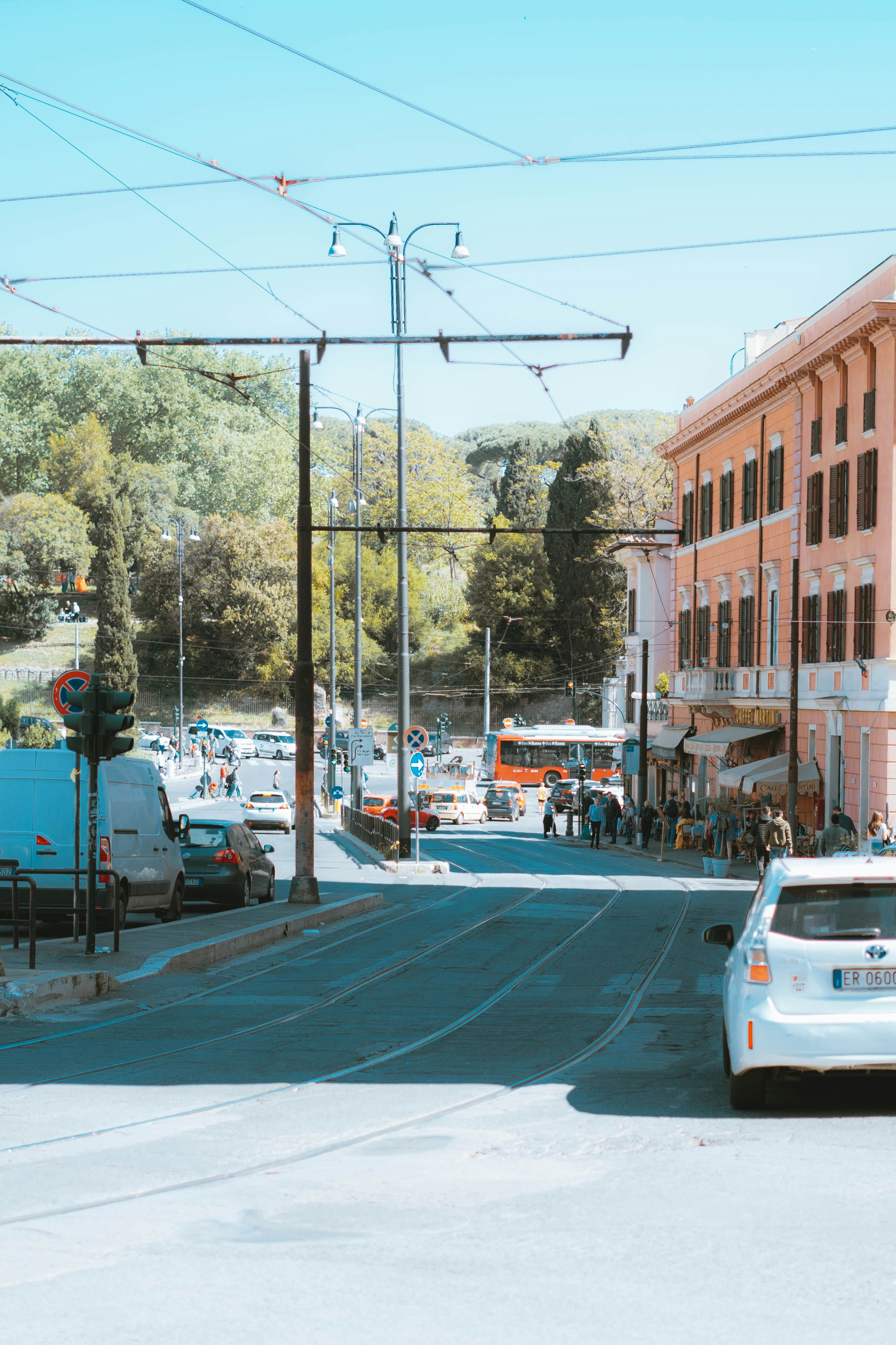 Busy street scene featuring vehicles and pedestrians navigating a vibrant urban environment with historic architecture.