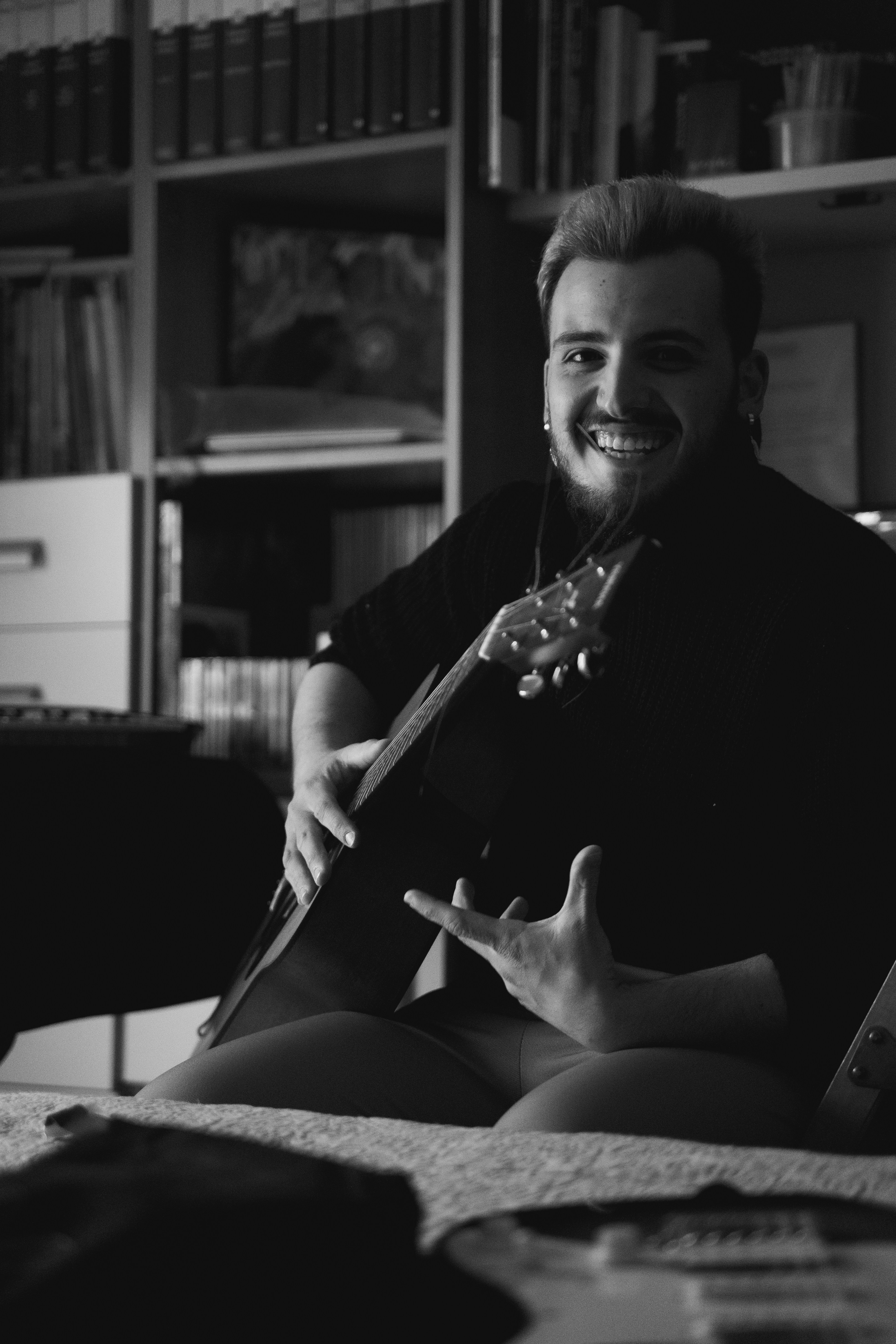 Home Studio Serenade: A Candid Guitar Moment Among Books