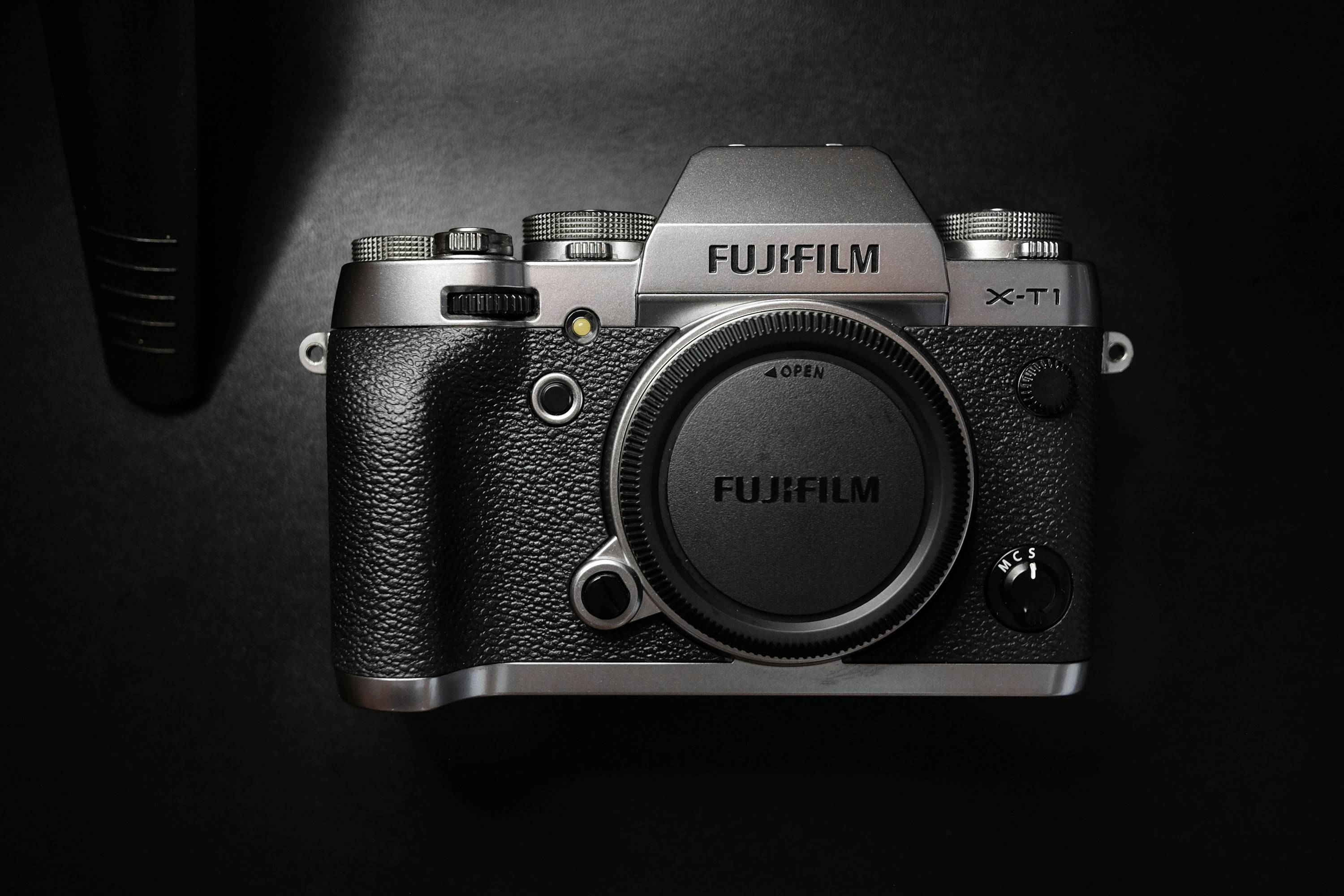 Silver Breath: A Fujifilm X70 Resting in Shadowed Studio Light