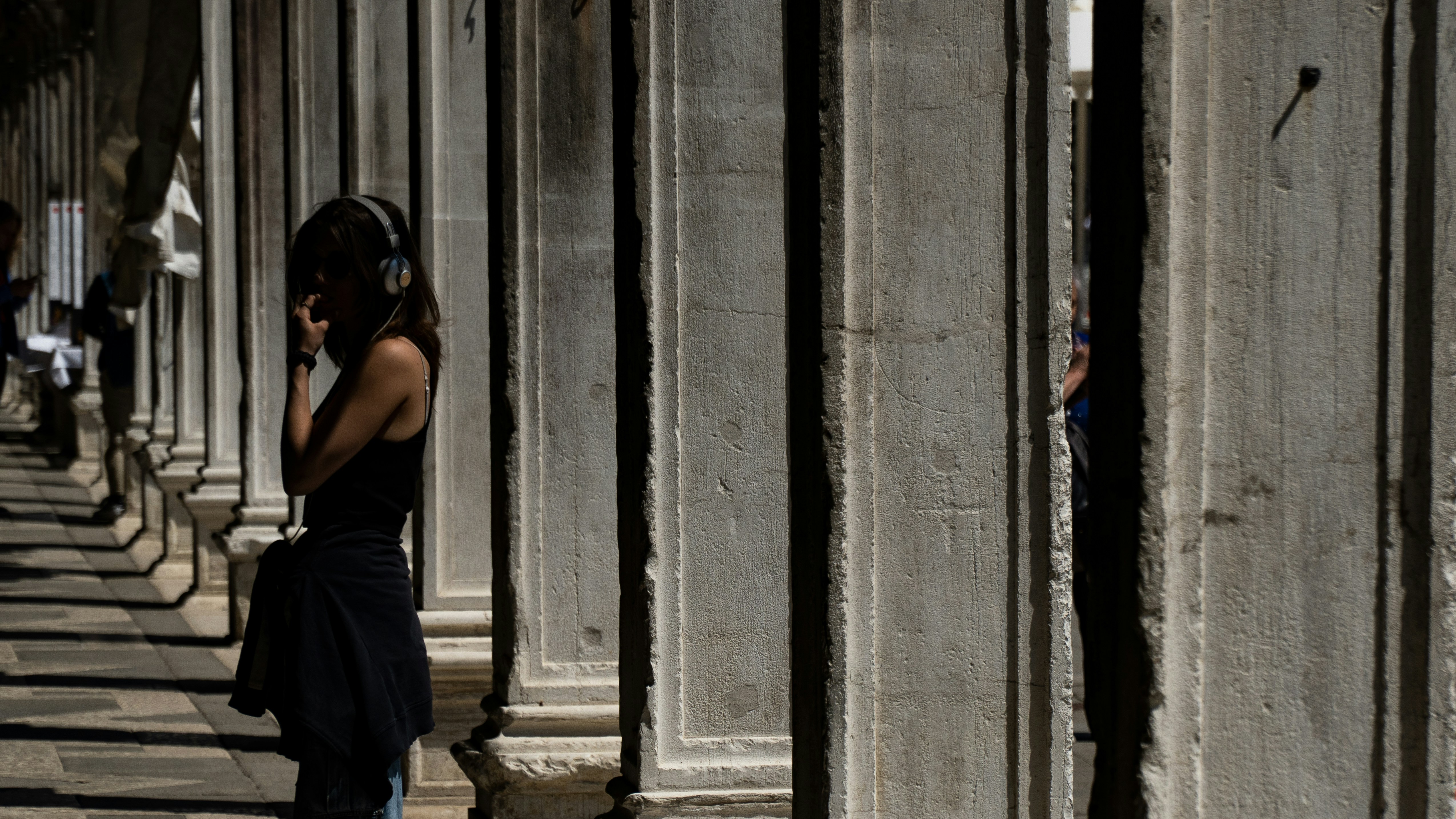 Solitary Contemplation in Sunlit Colonnade