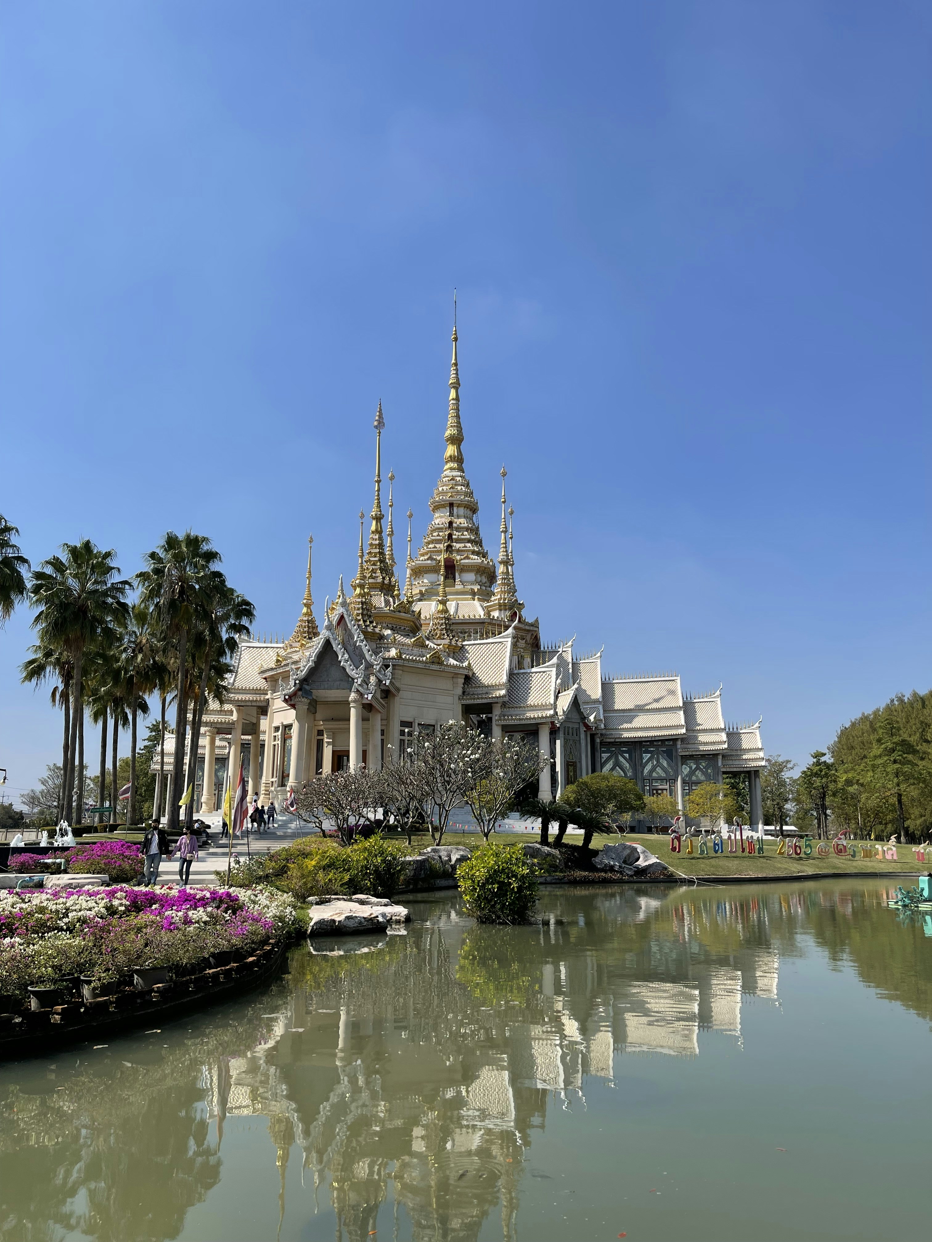 A building with a tower and spires by a body of water photo – Free วัด ...
