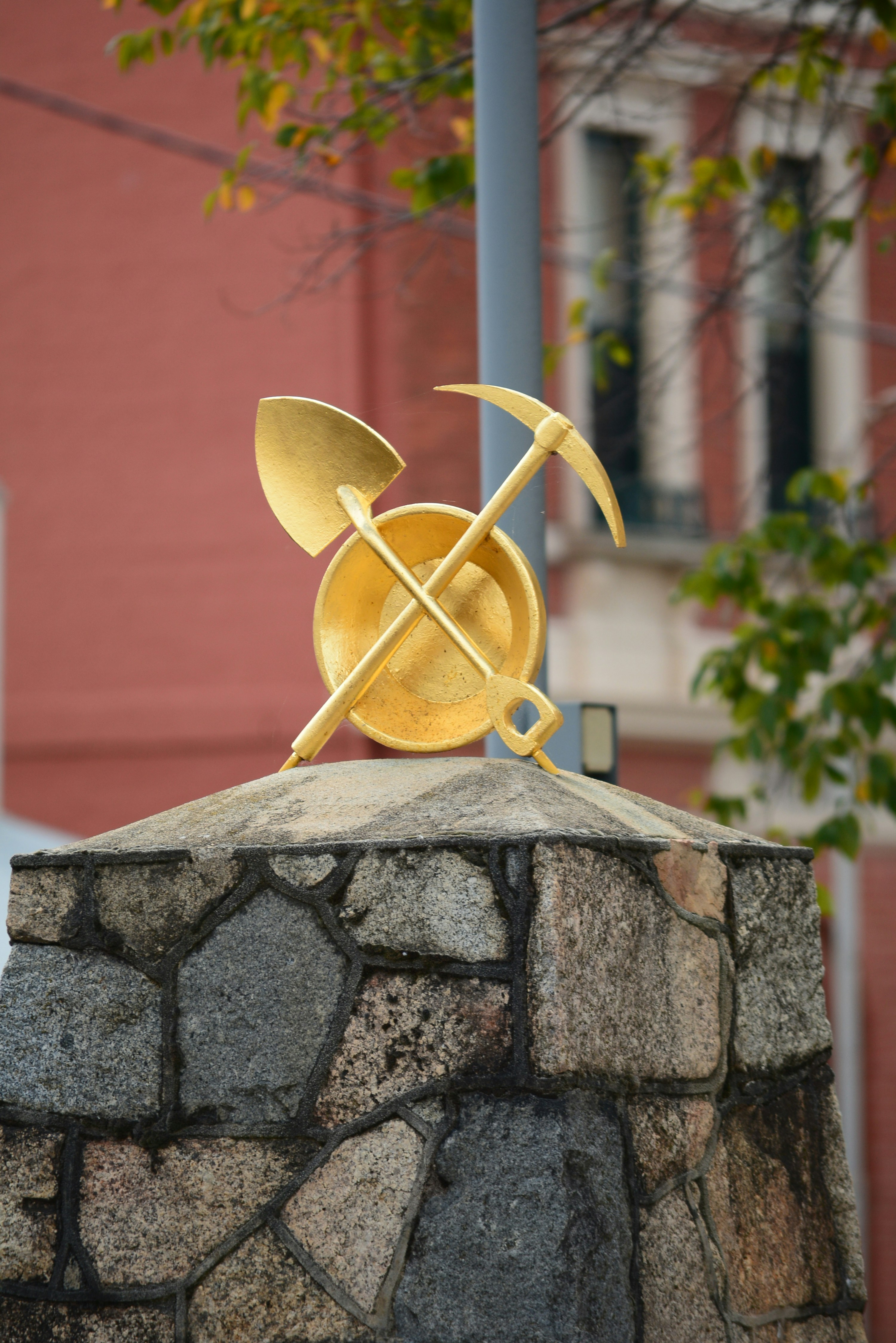Gilded Tools Crown a Weathered Pedestal