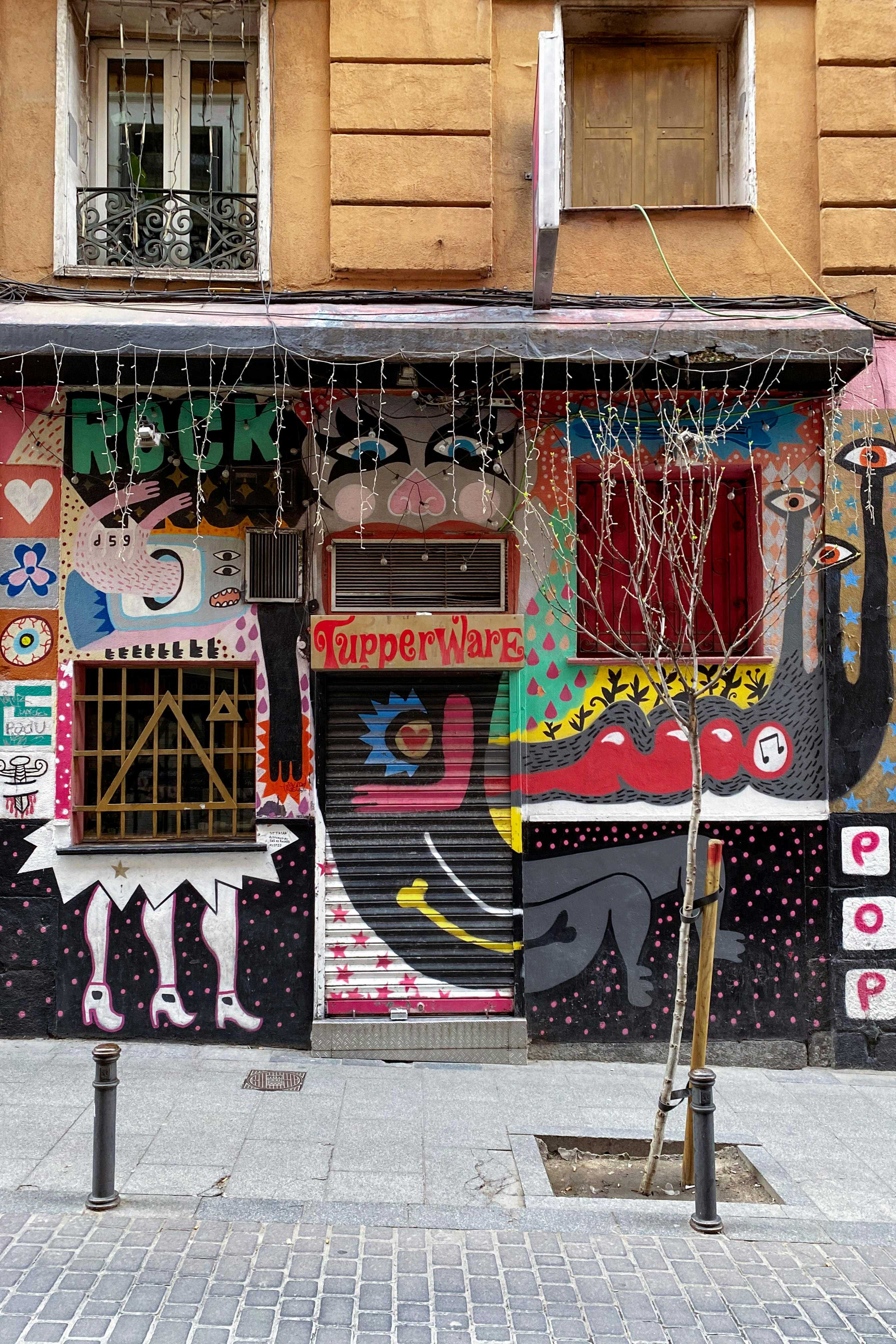 TupperWare Alley: A Color-Splashed Facade Under String Lights